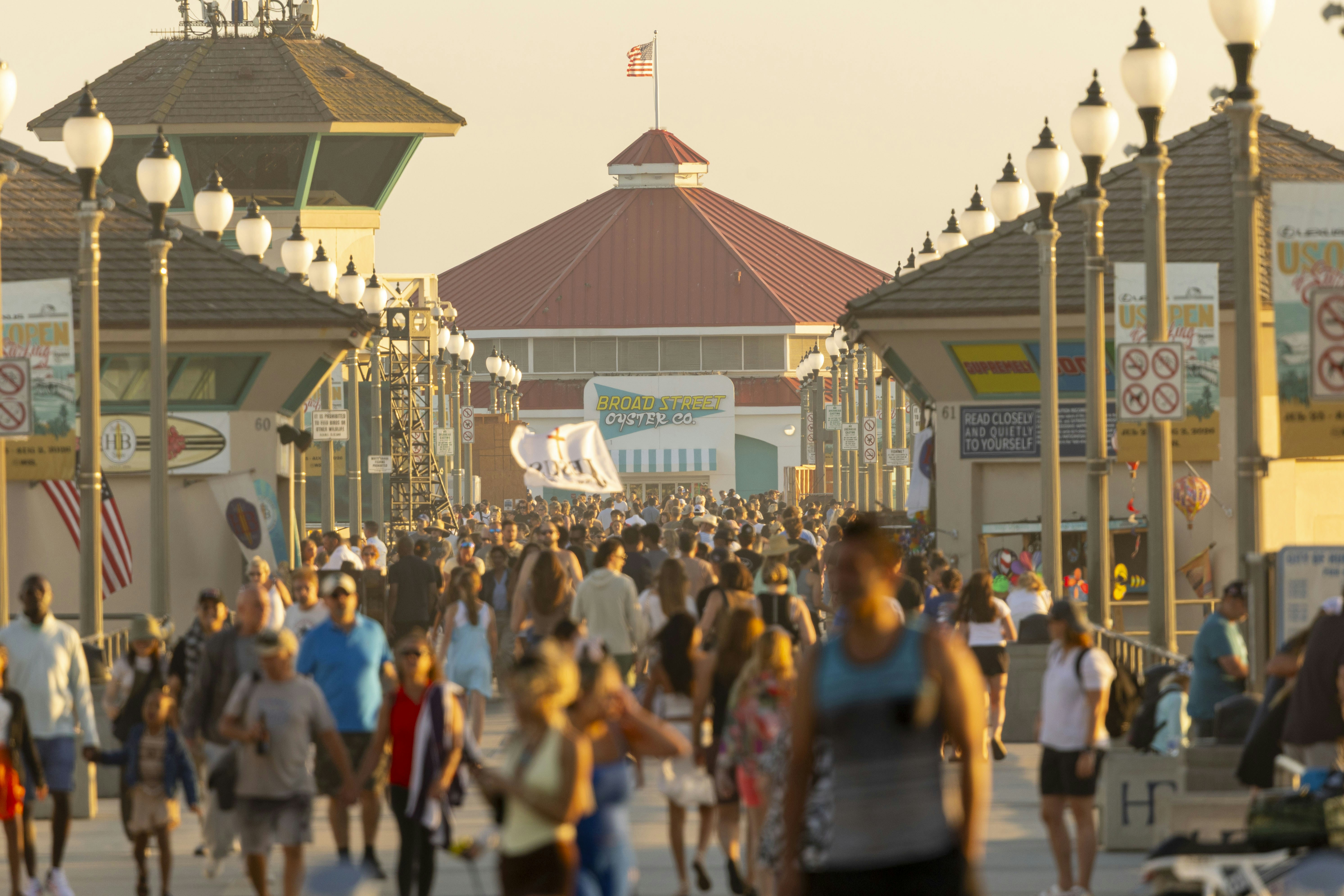 Sunlit Boardwalk Crowds Head Toward a Central Pavilion