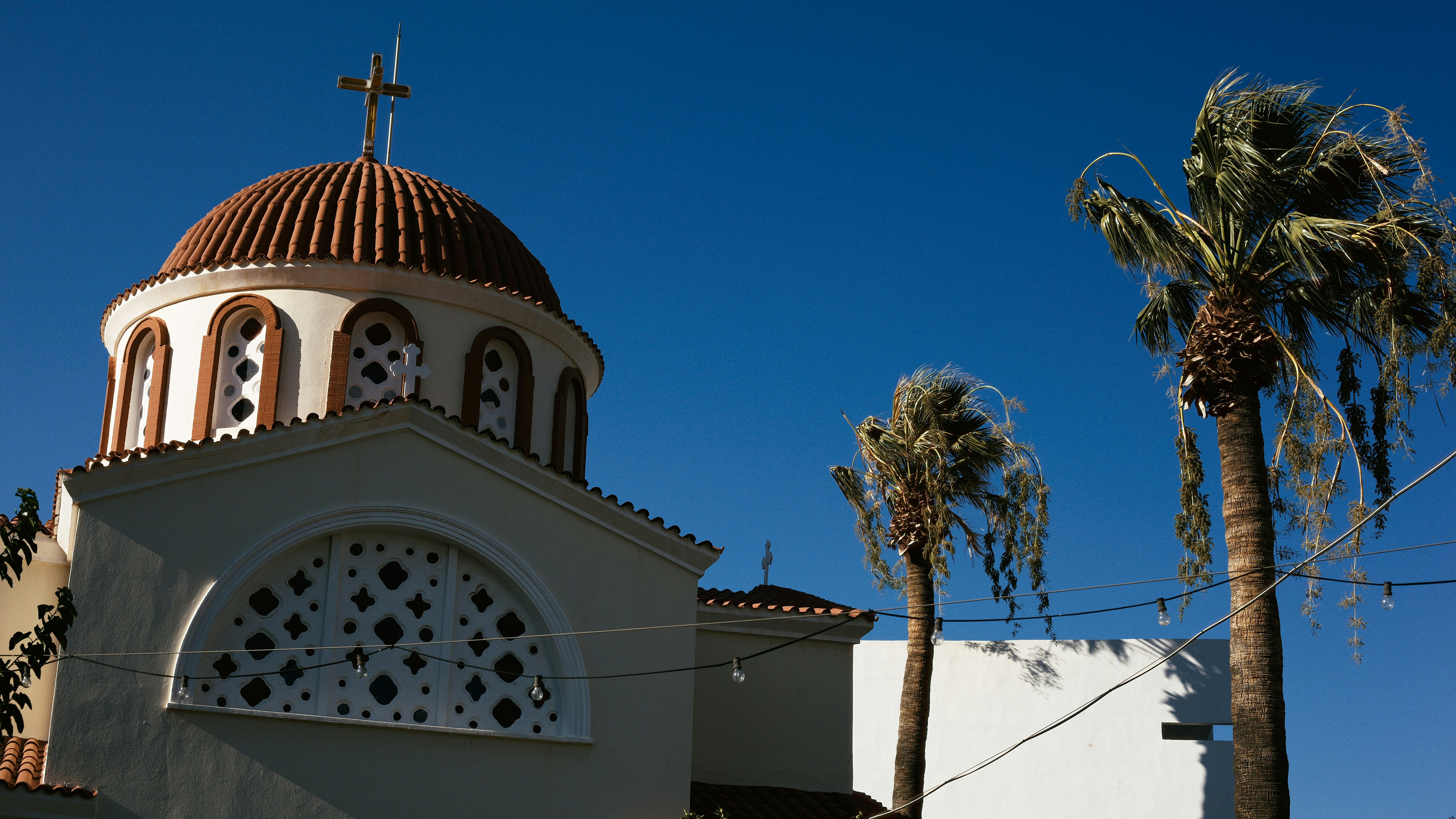 Dome of a Mediterranean chapel under a clear blue sky