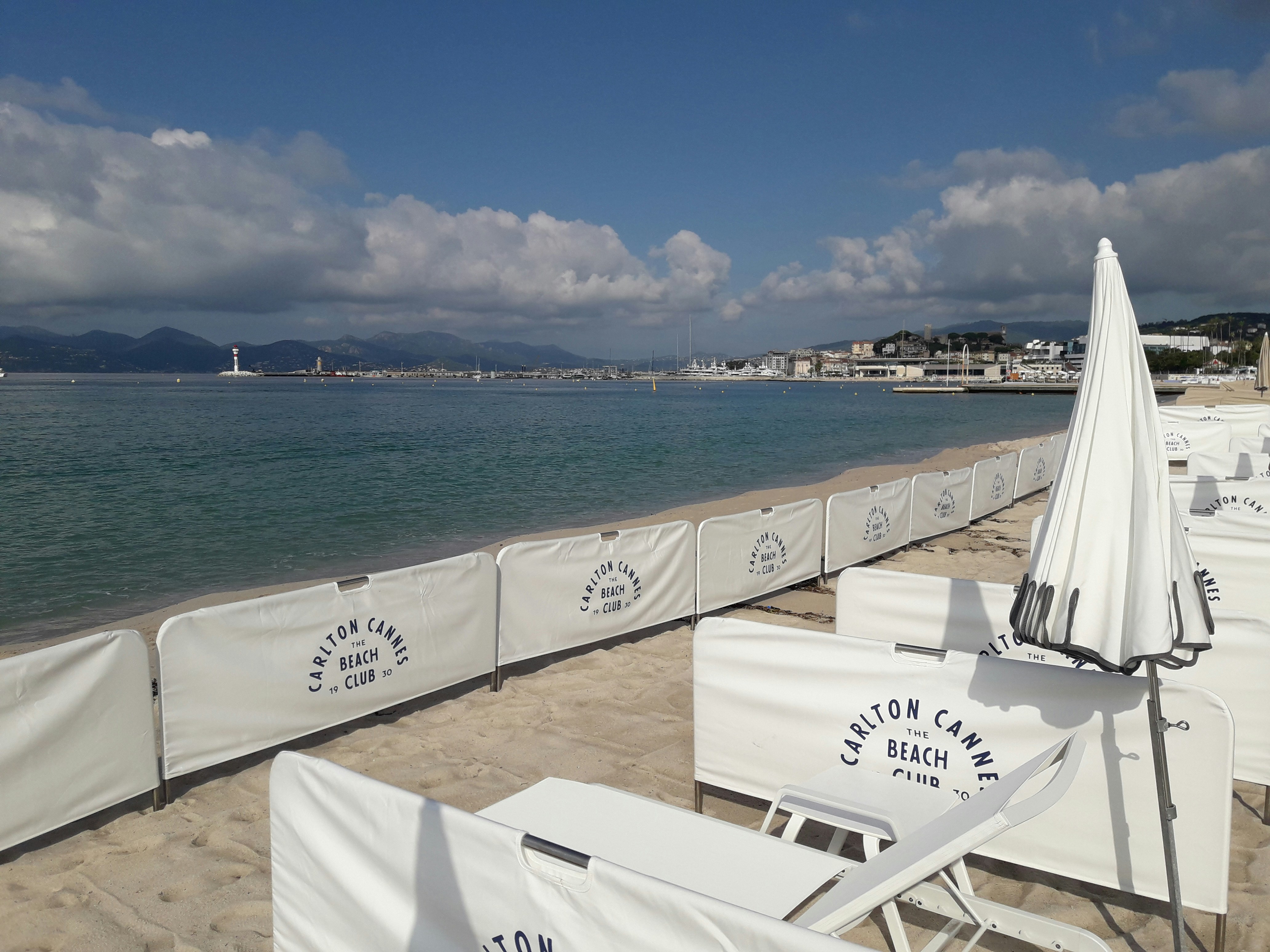 Sunlit Beachfront Strips and Lounge Chairs by the Calm Sea