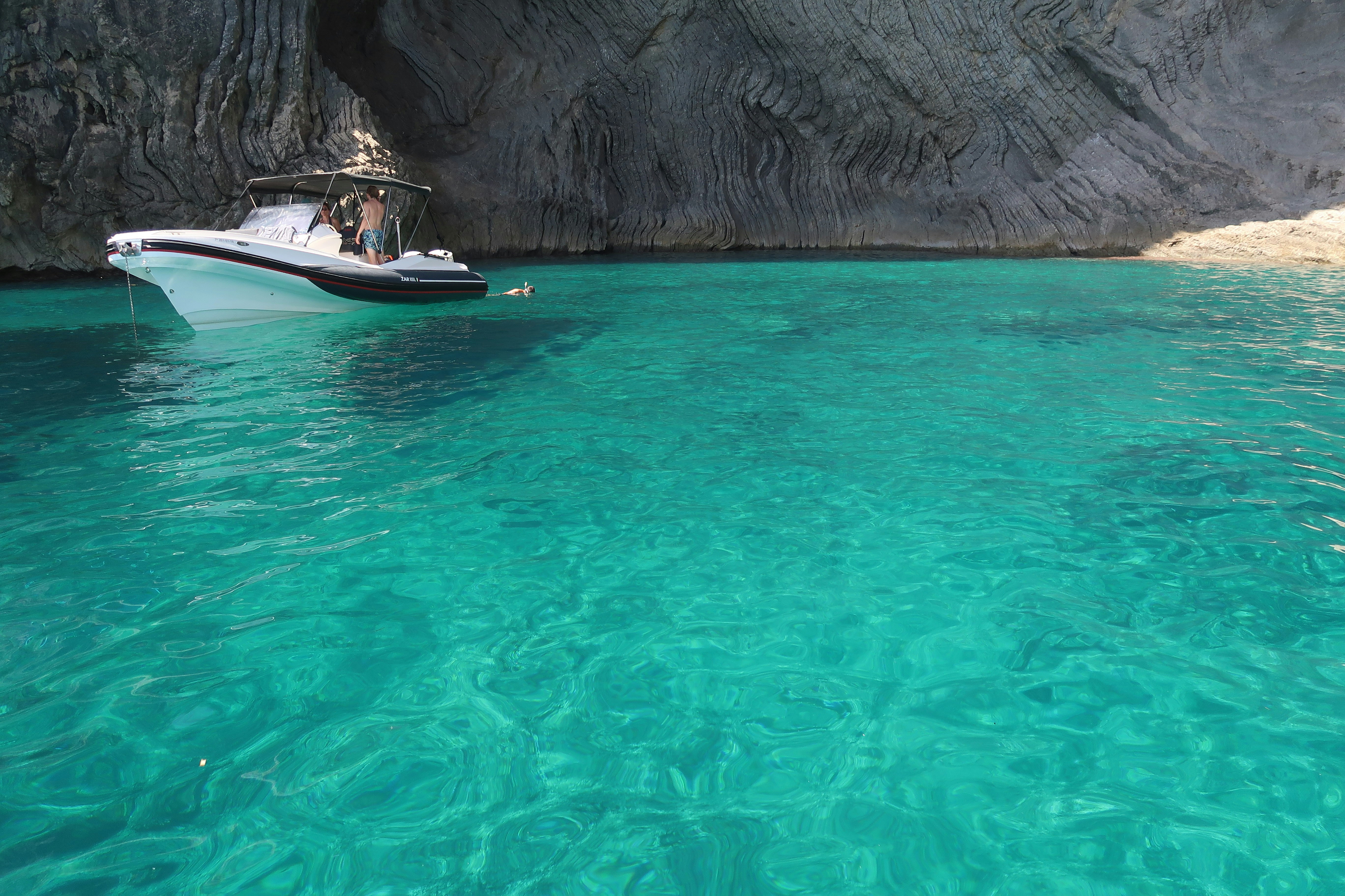 Turquoise Cove: A Boat Anchored by Limestone Cliffs