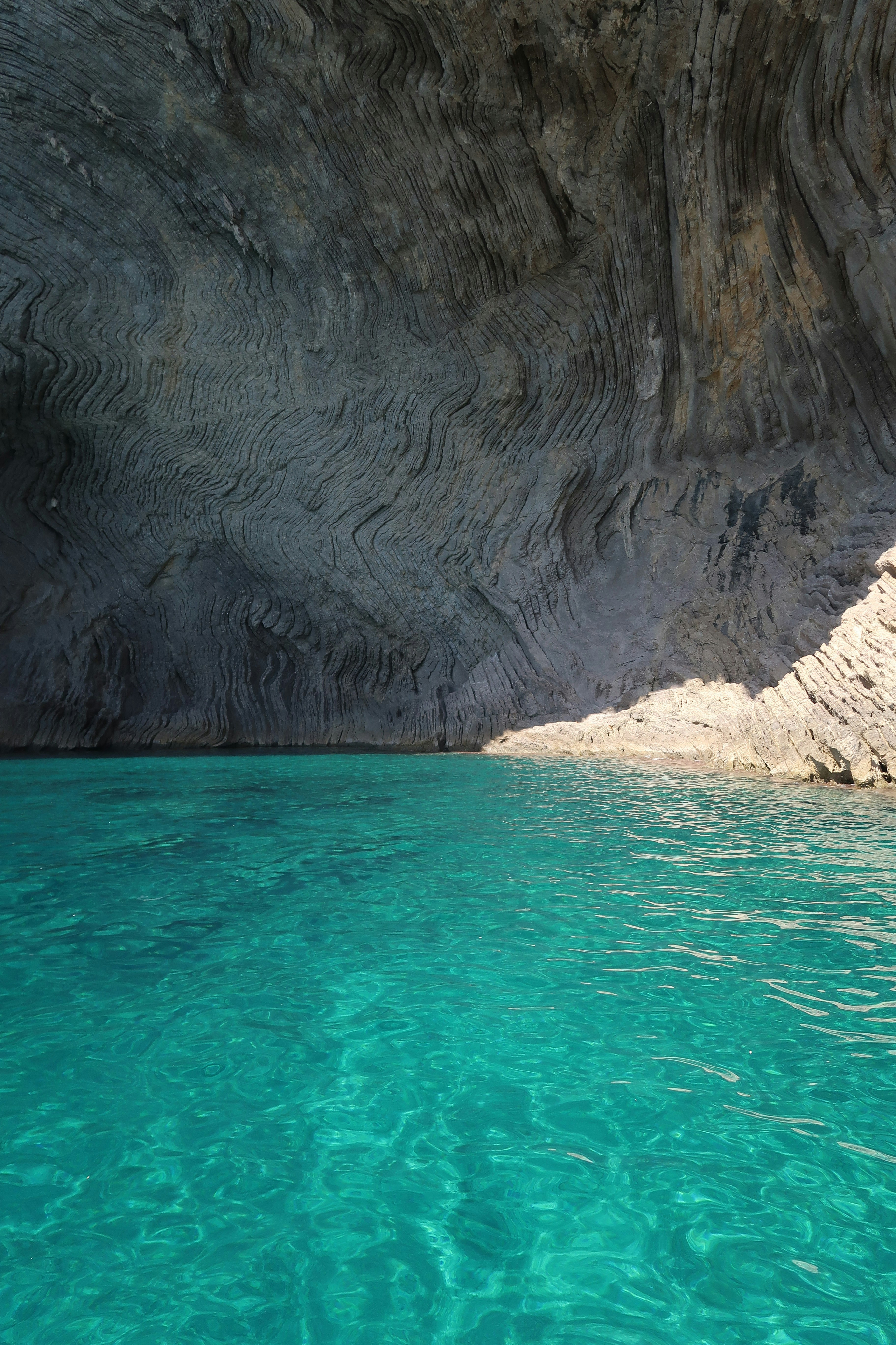 Turquoise Cove Beneath Ridged Cliff