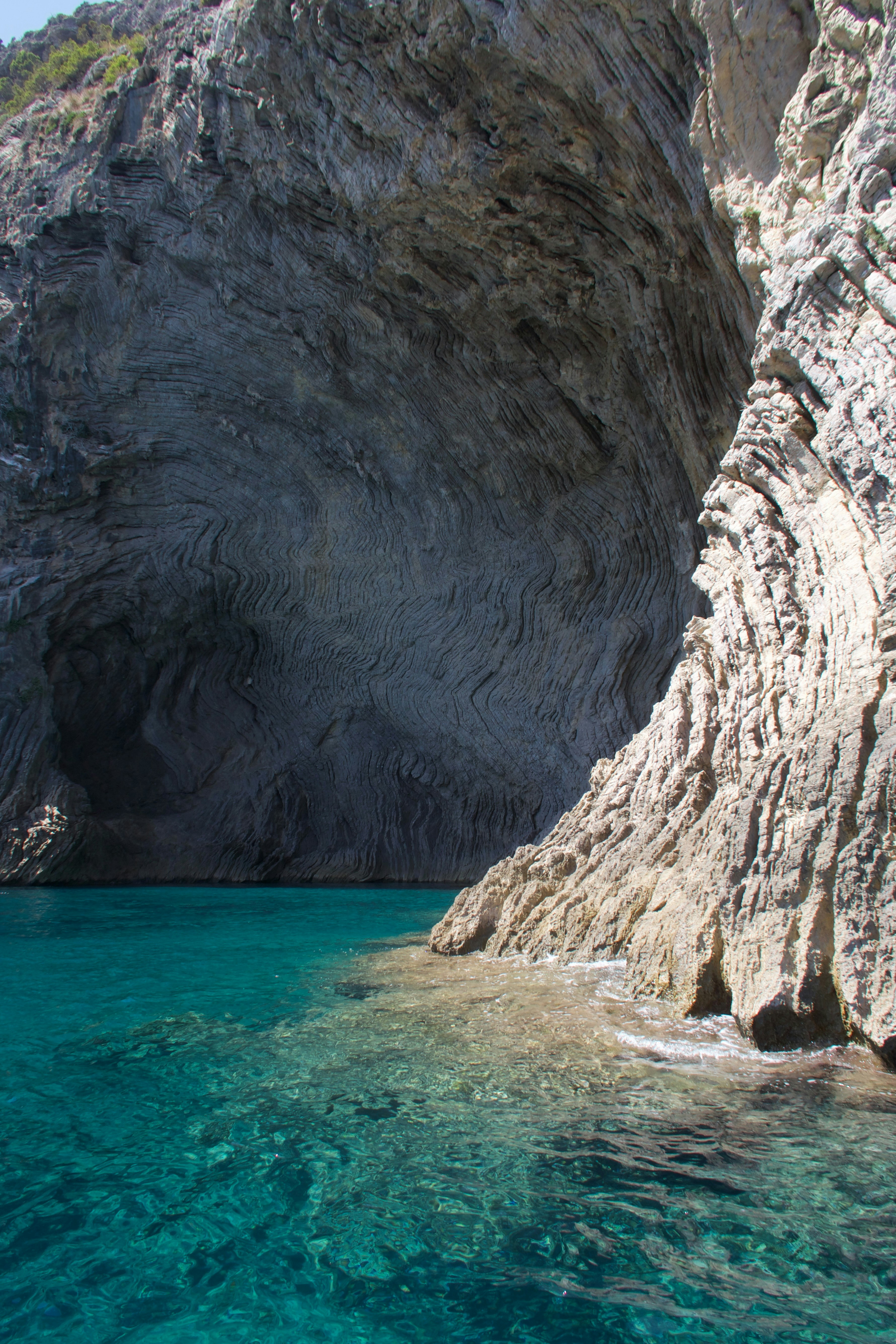 Emerald Cove: Where Sea Meets Shadowed Cliff