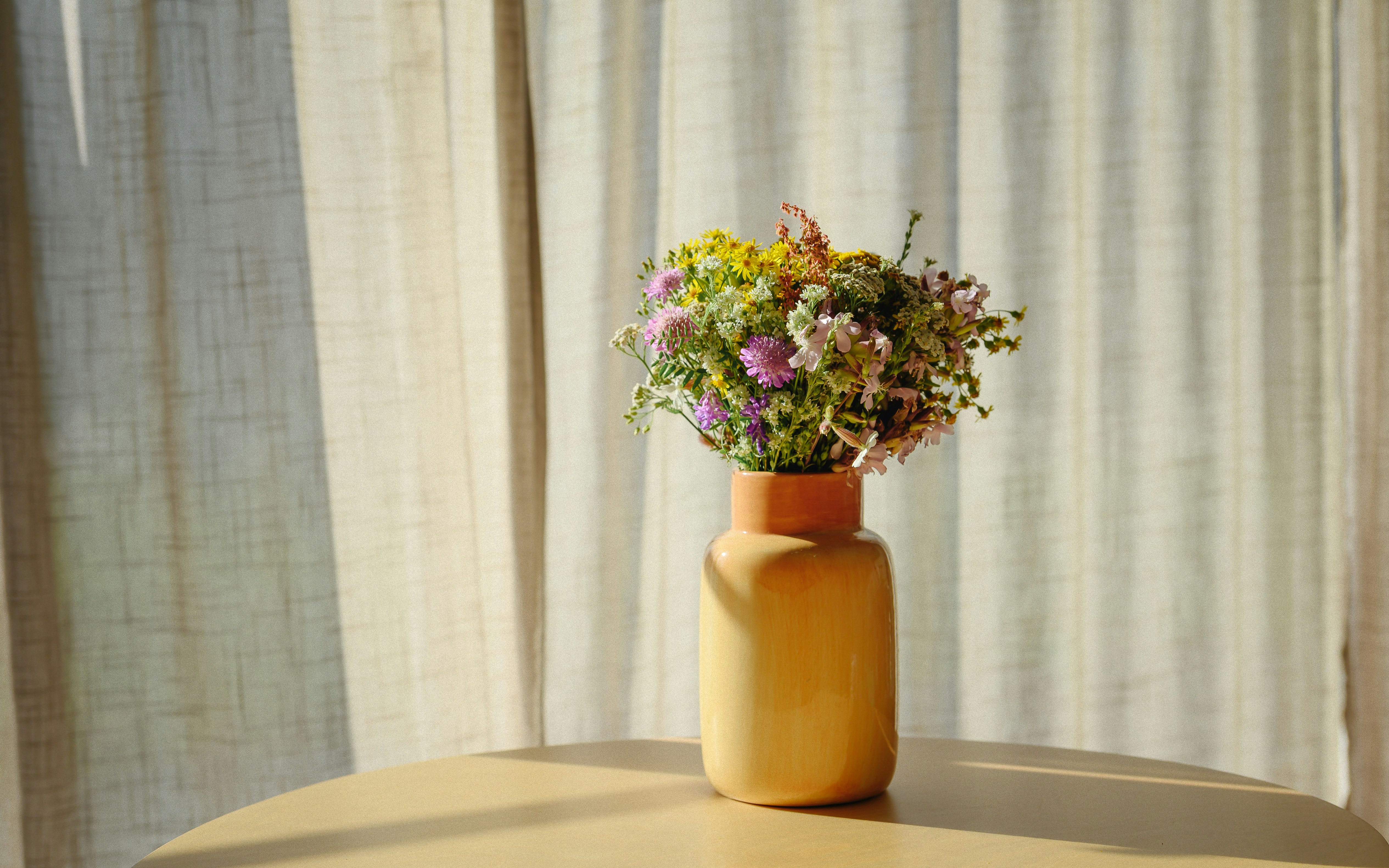 Sunlit Still Life: A Golden Vase Cradling Fresh Spring Blooms