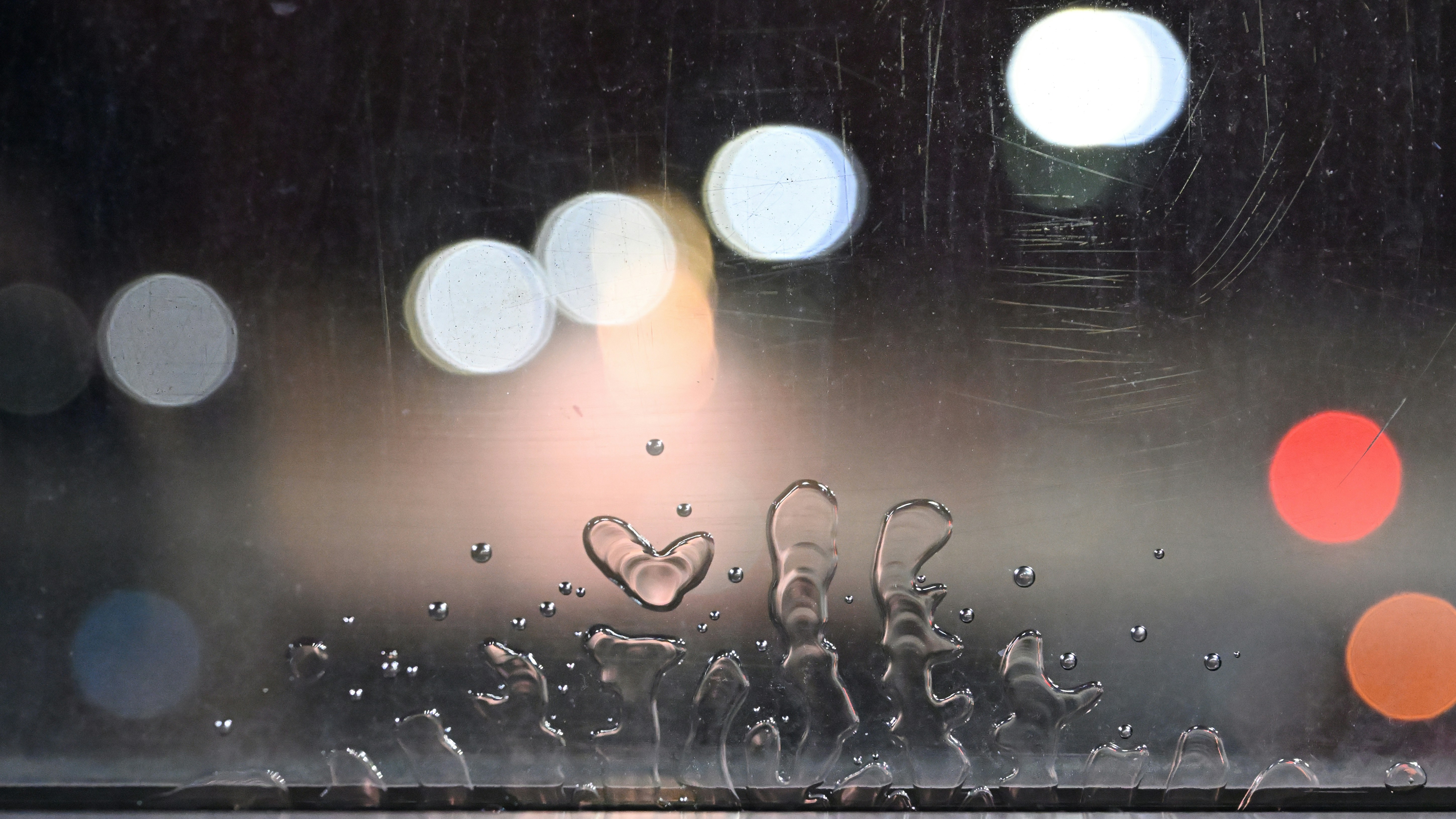Blurry City Glow Through a Rain-Streaked Windshield