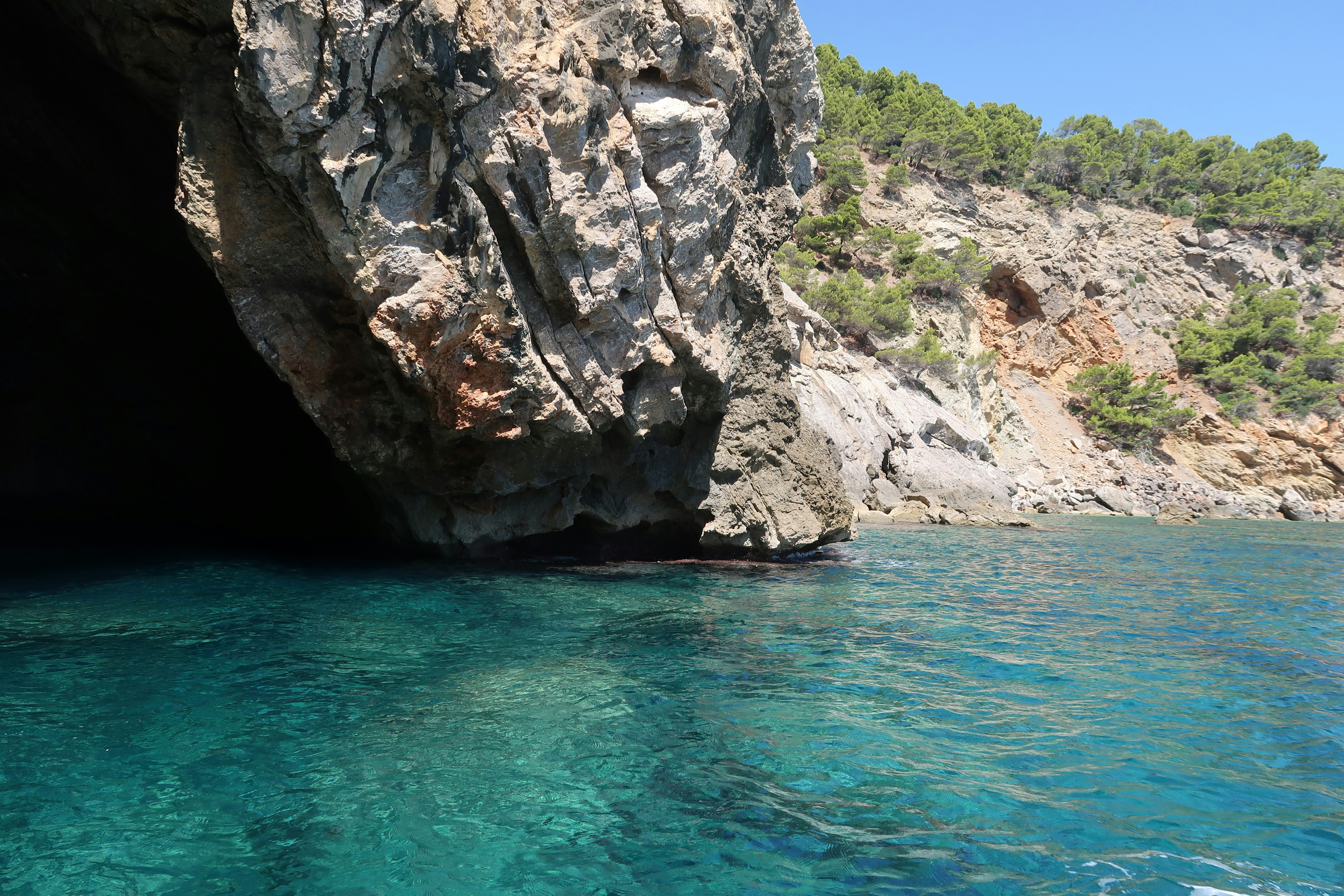 Sea Cave Rendezvous: Turquoise Waters Lapping at a Cliff's Edge