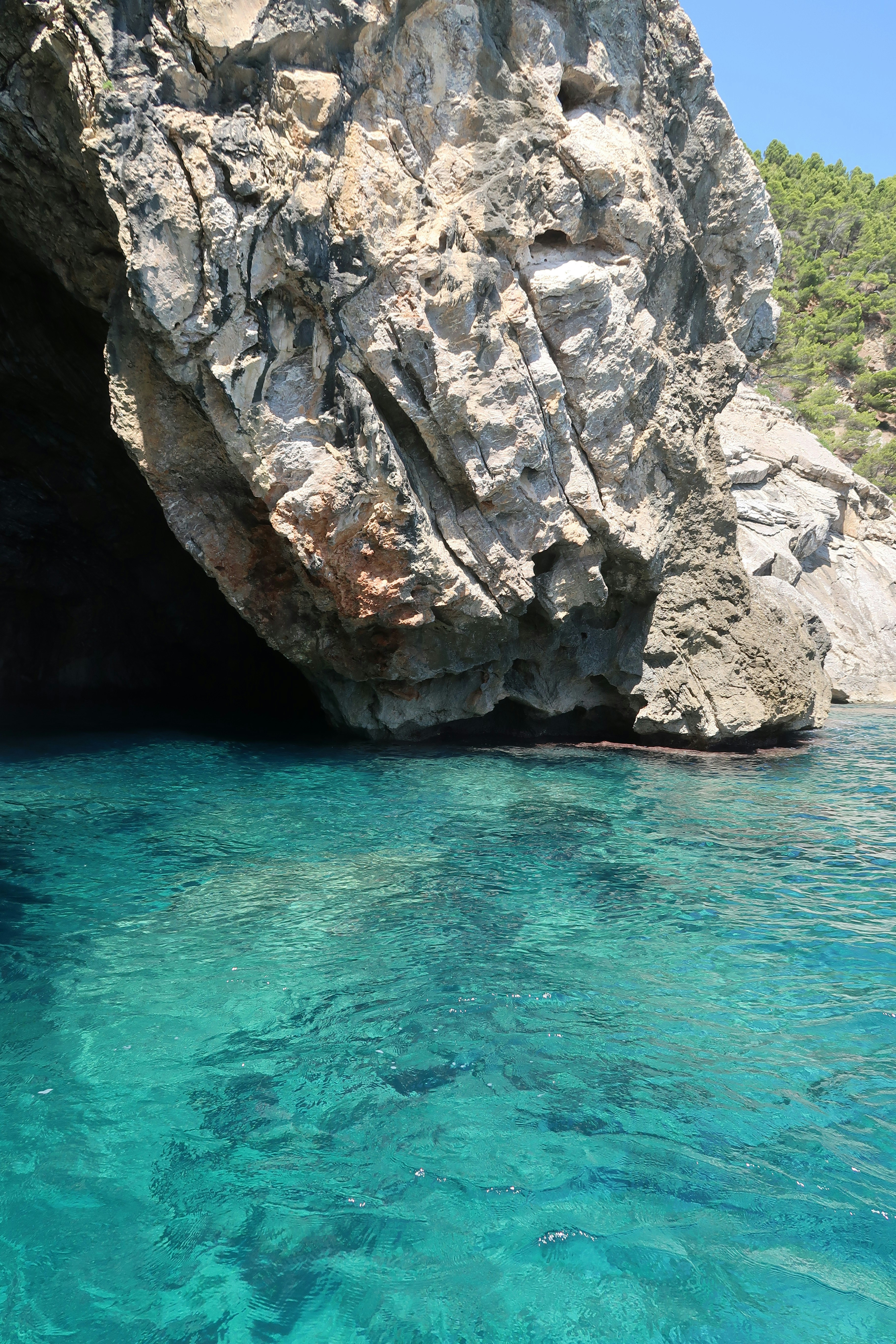 Into the turquoise cave: sunlight, rock, and sea meet at the waterline