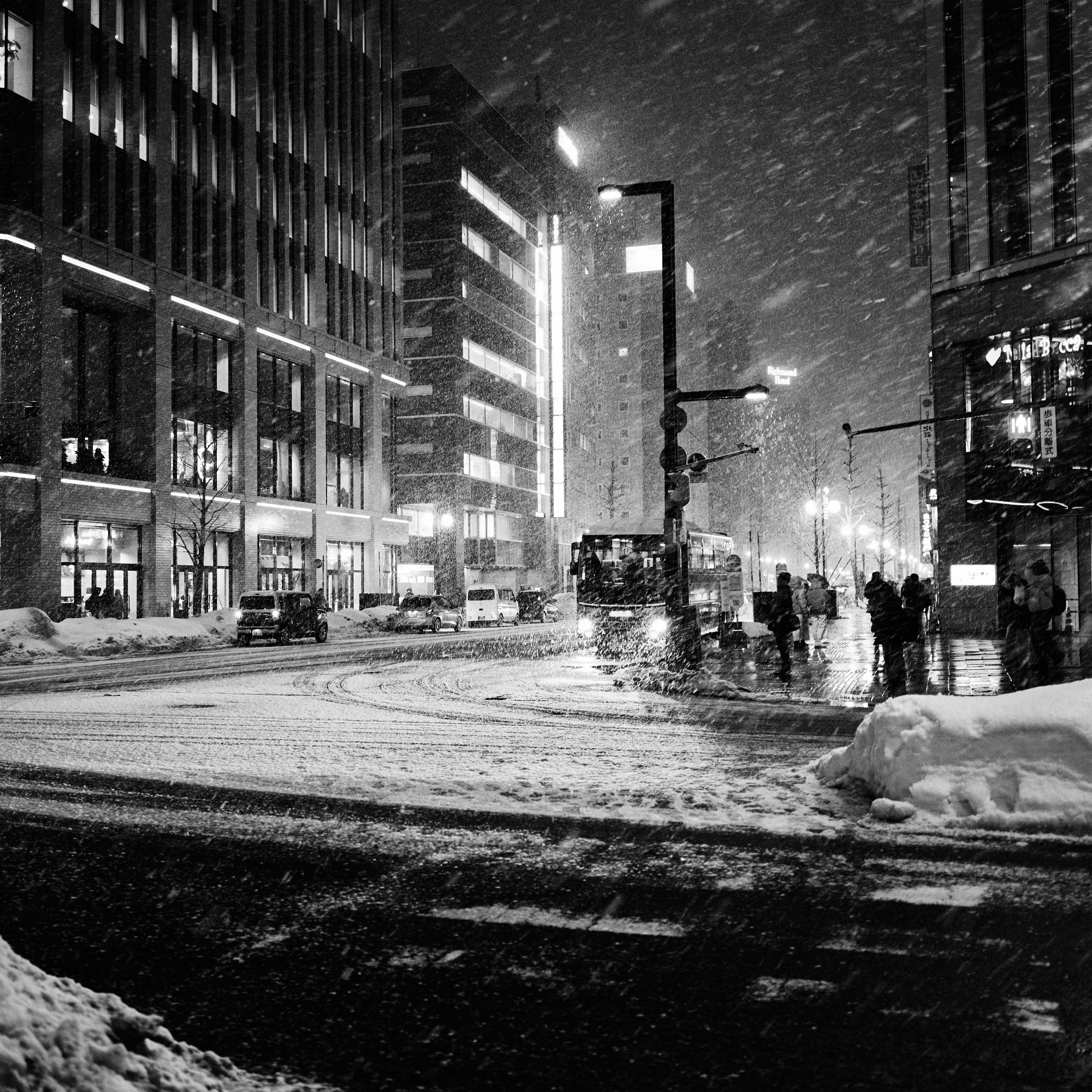 Snowfall on a City Street at Night: Neon Light Trails and Quiet Pedestrians