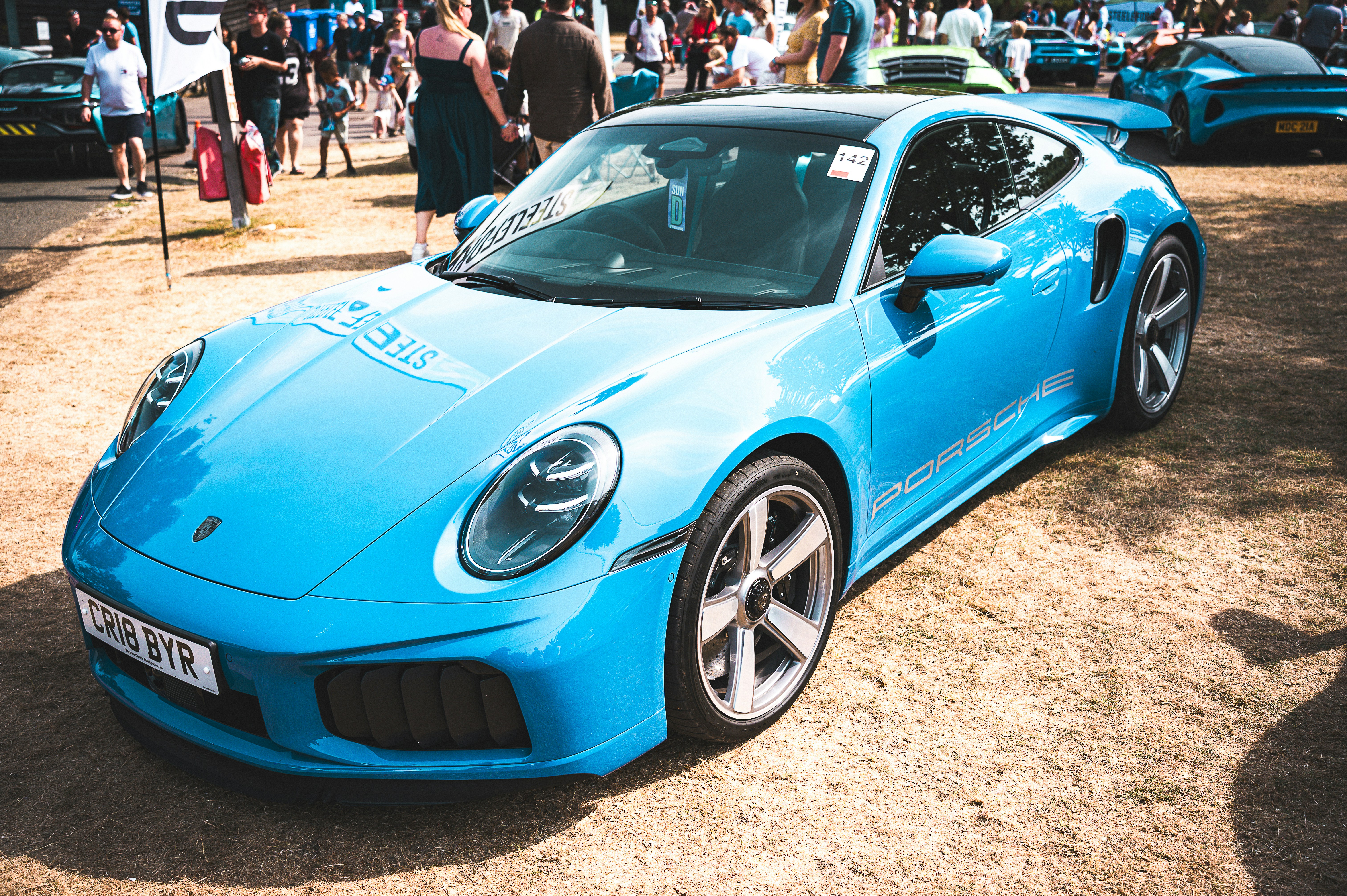 Blue Porsche Sprints at a Car Show