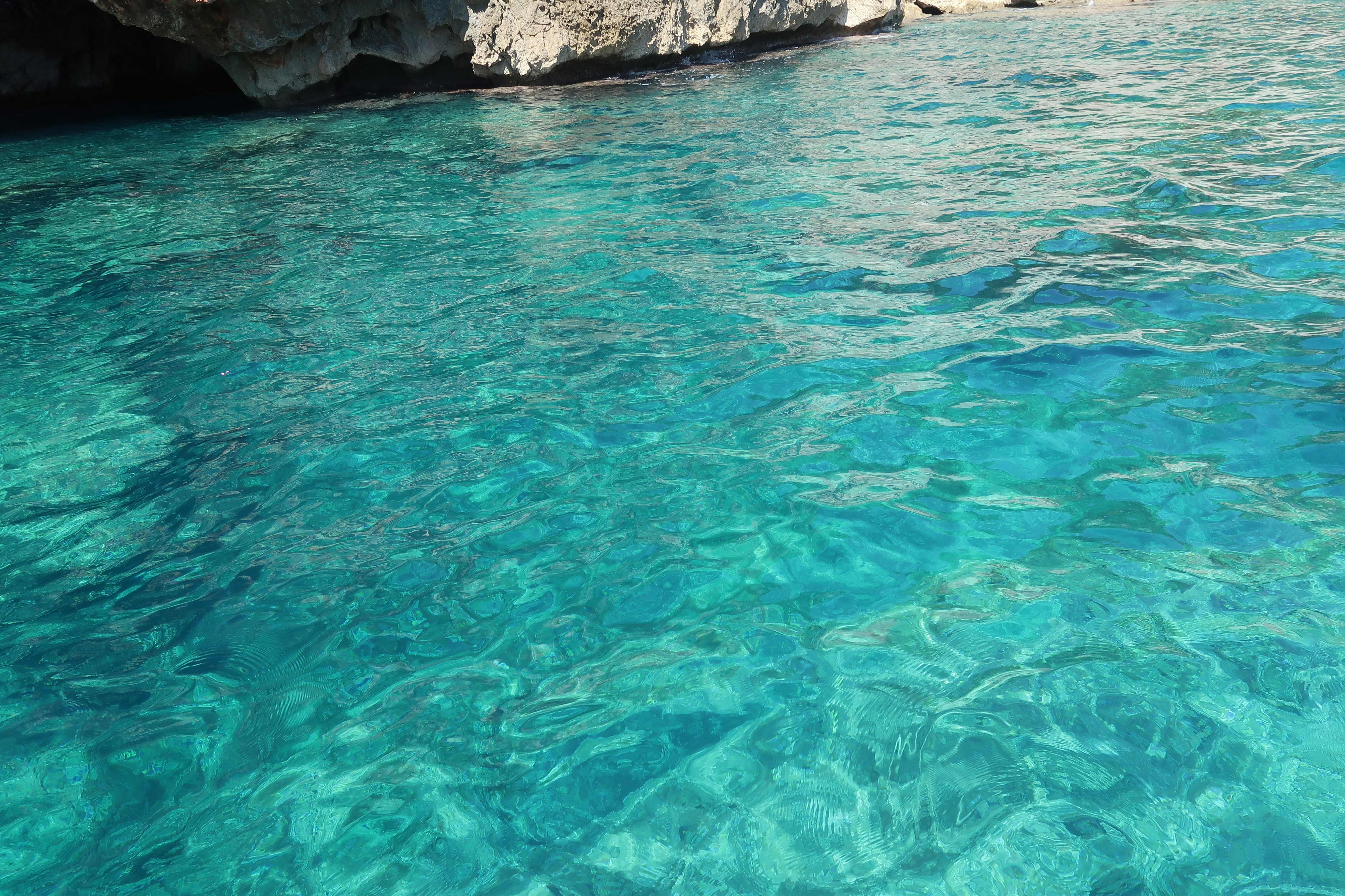 Aqua Grotto: Sunlit Turquoise Sea through a Coastal Edge