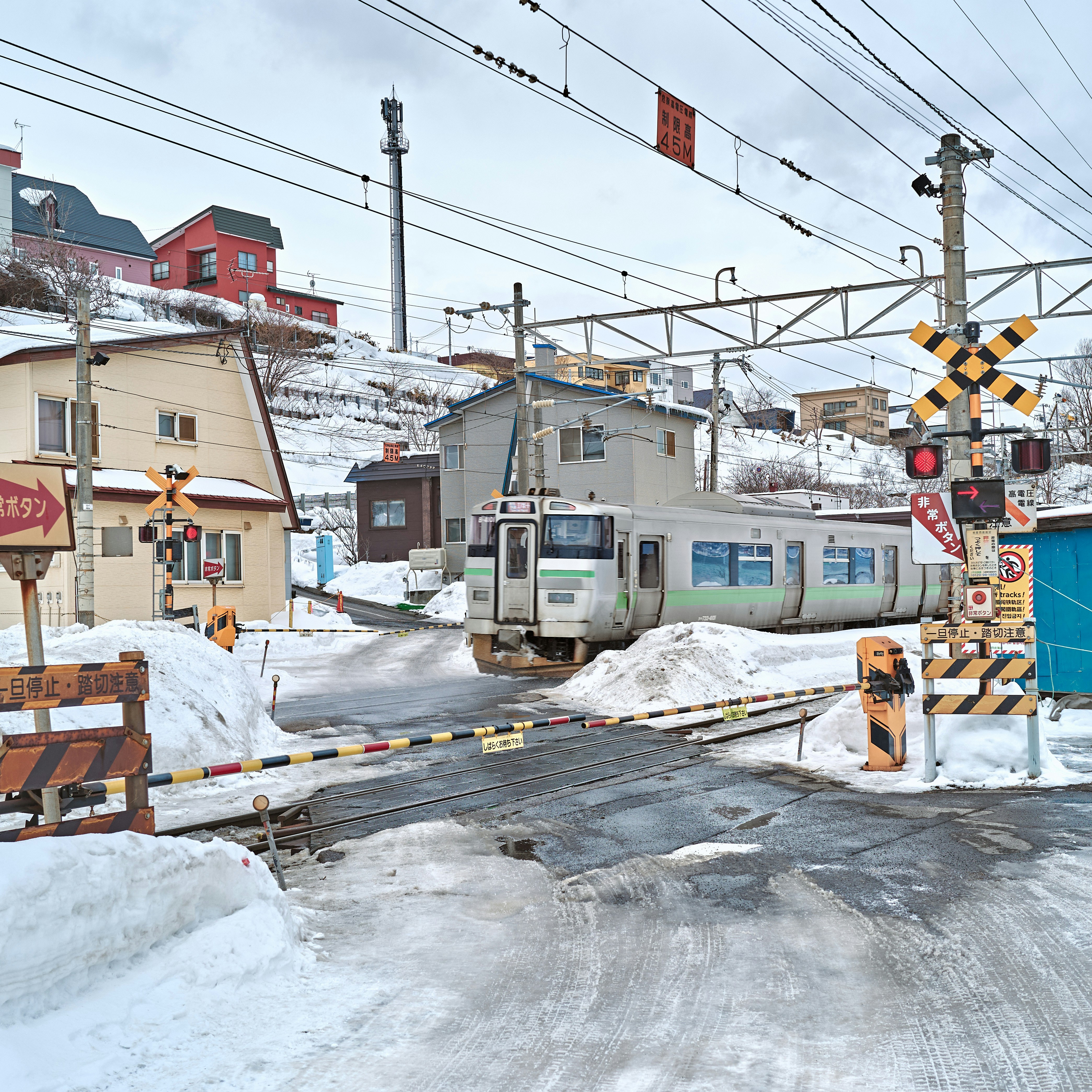 Snow-covered Crossing: A Tranquil Train Passes a Quiet Village