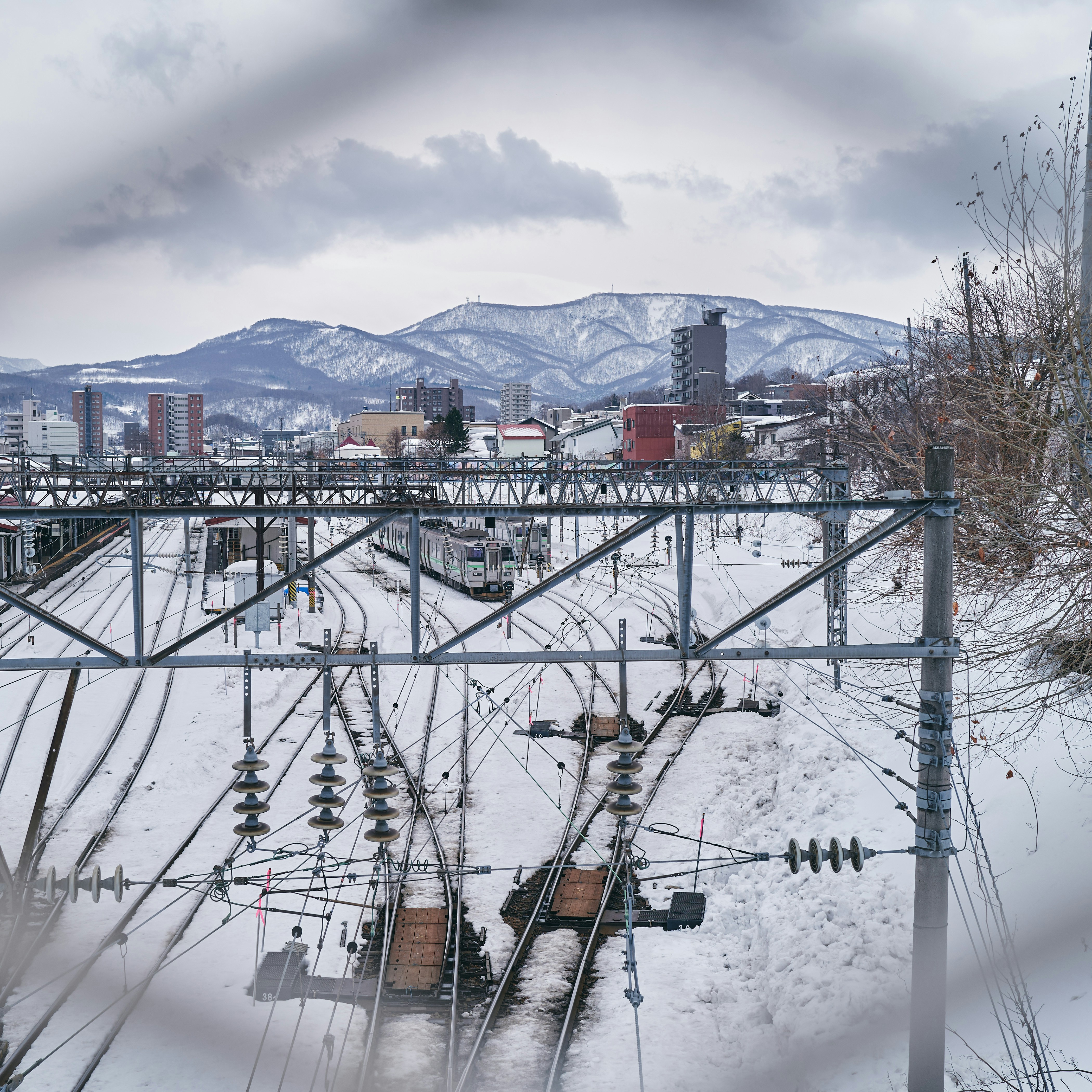 Railway Veins Through Snow: Snow-Covered Tracks to a Winter City