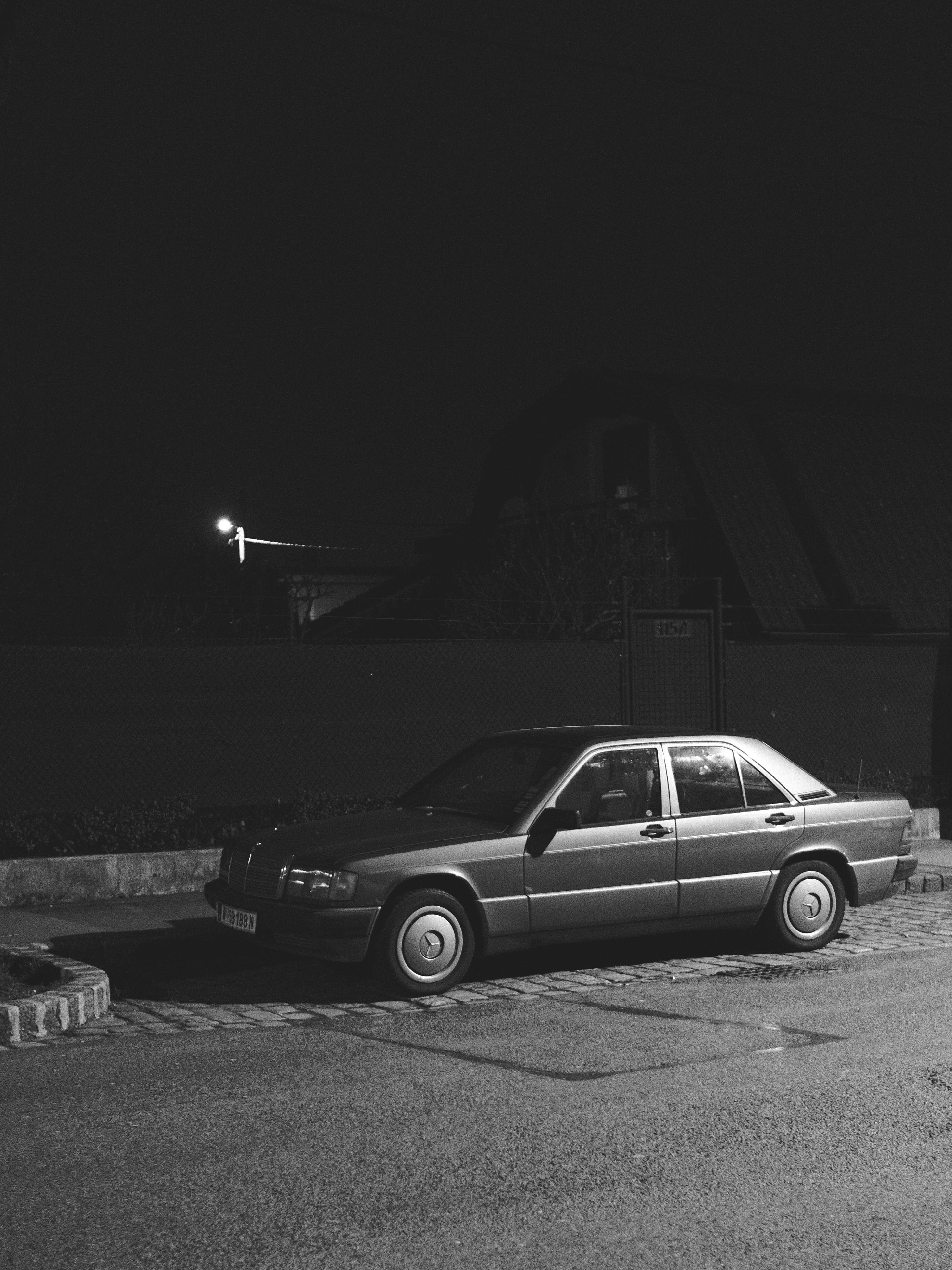 Nighttime Highway Ghost: A Silver Sedan Quietly Anchors the Streetlight