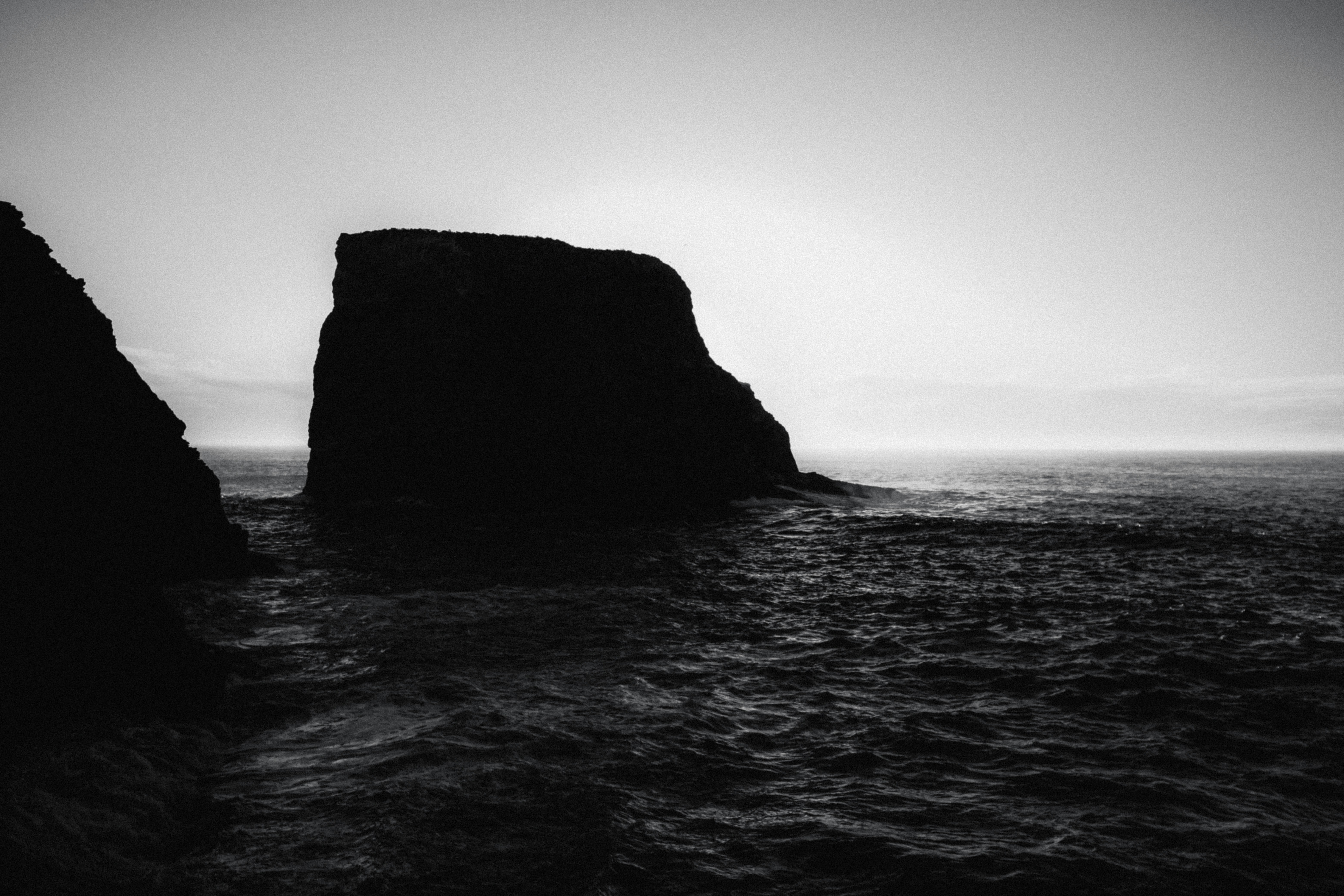Midnight Monolith: A Lone Sea Cliff Between Quiet Horizons