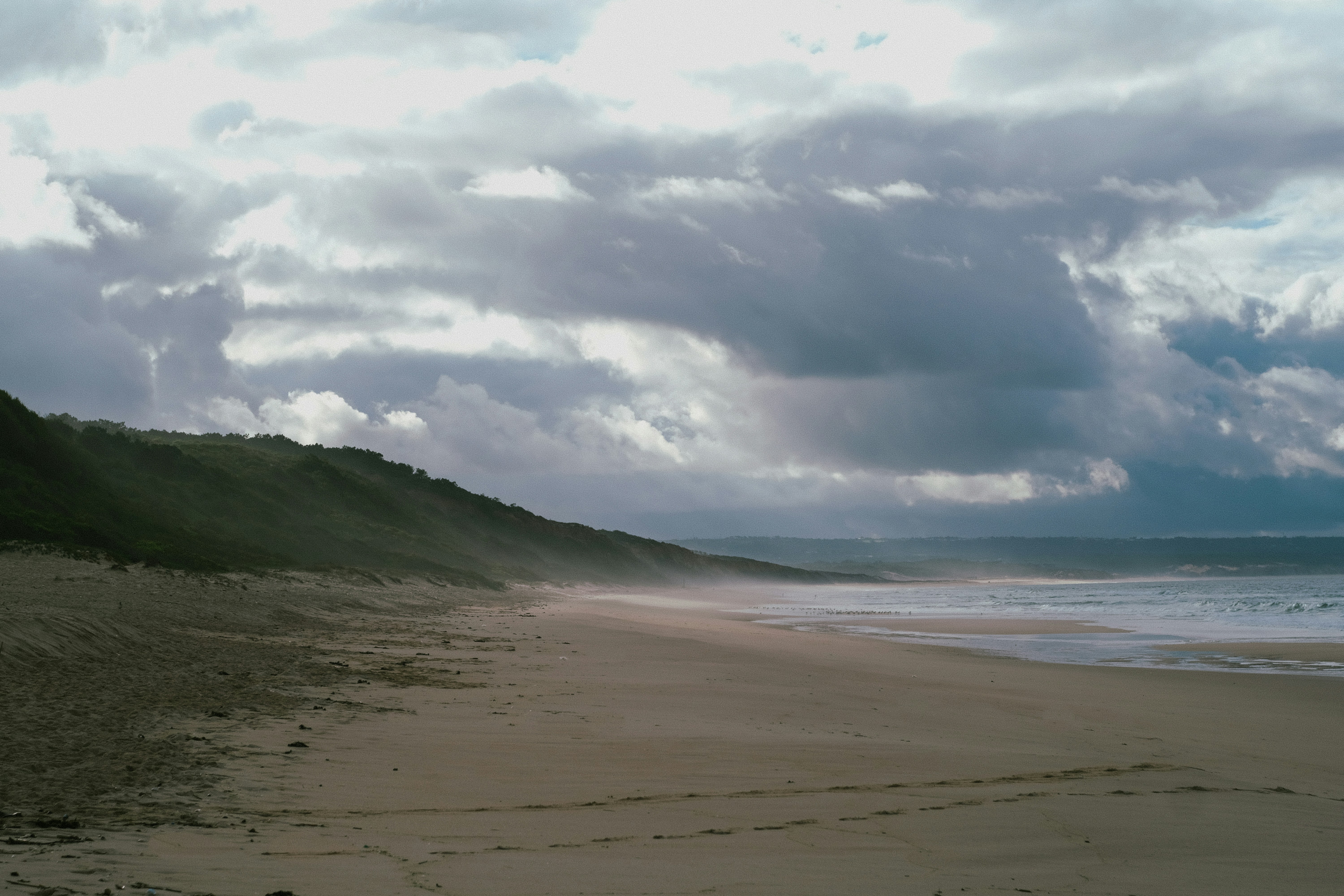 Quiet Coastal Lines: Distant Hills Meet the Wind-Carved Shore