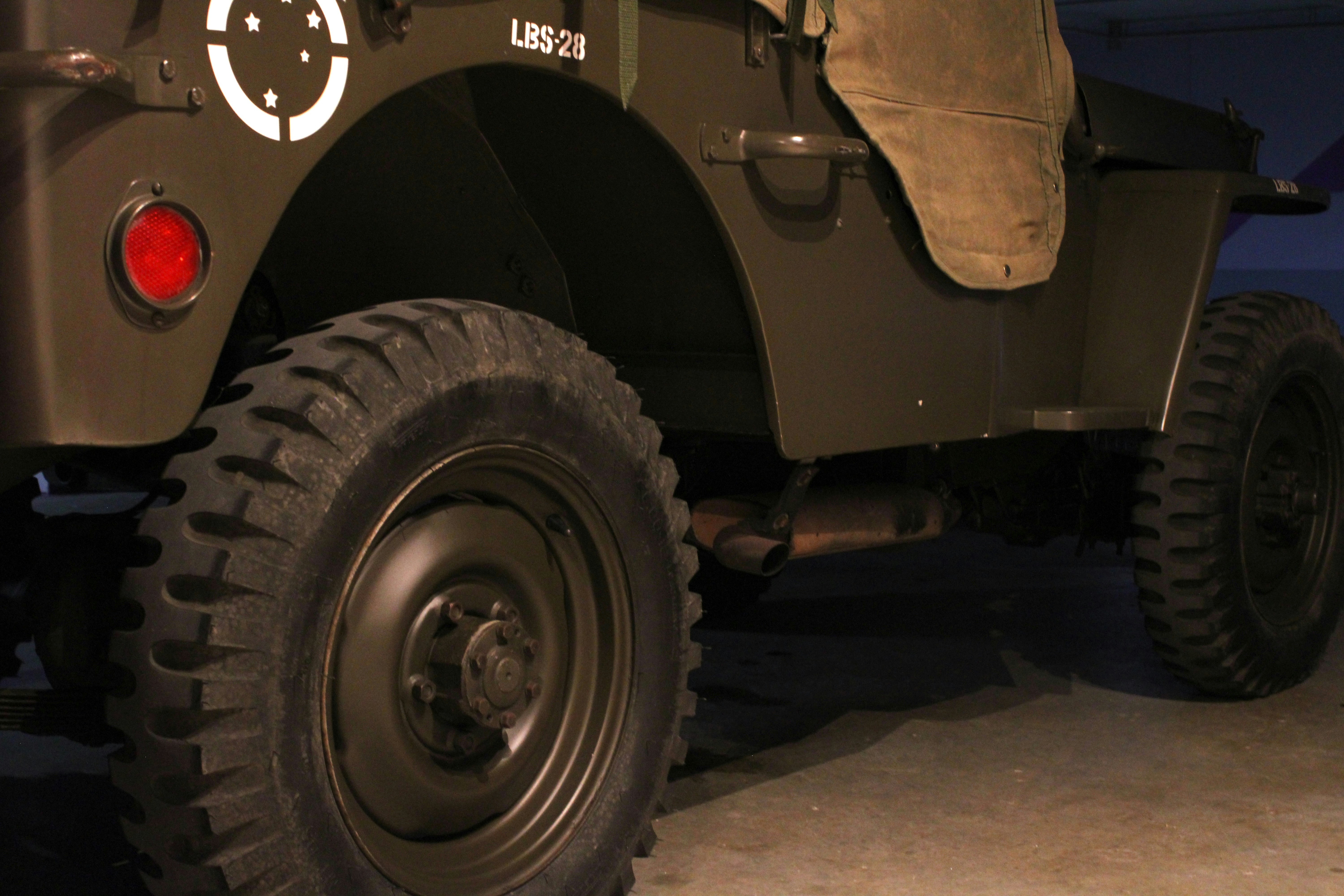 Grounded Steel: close-up of a military vehicle wheel and fender under dim light