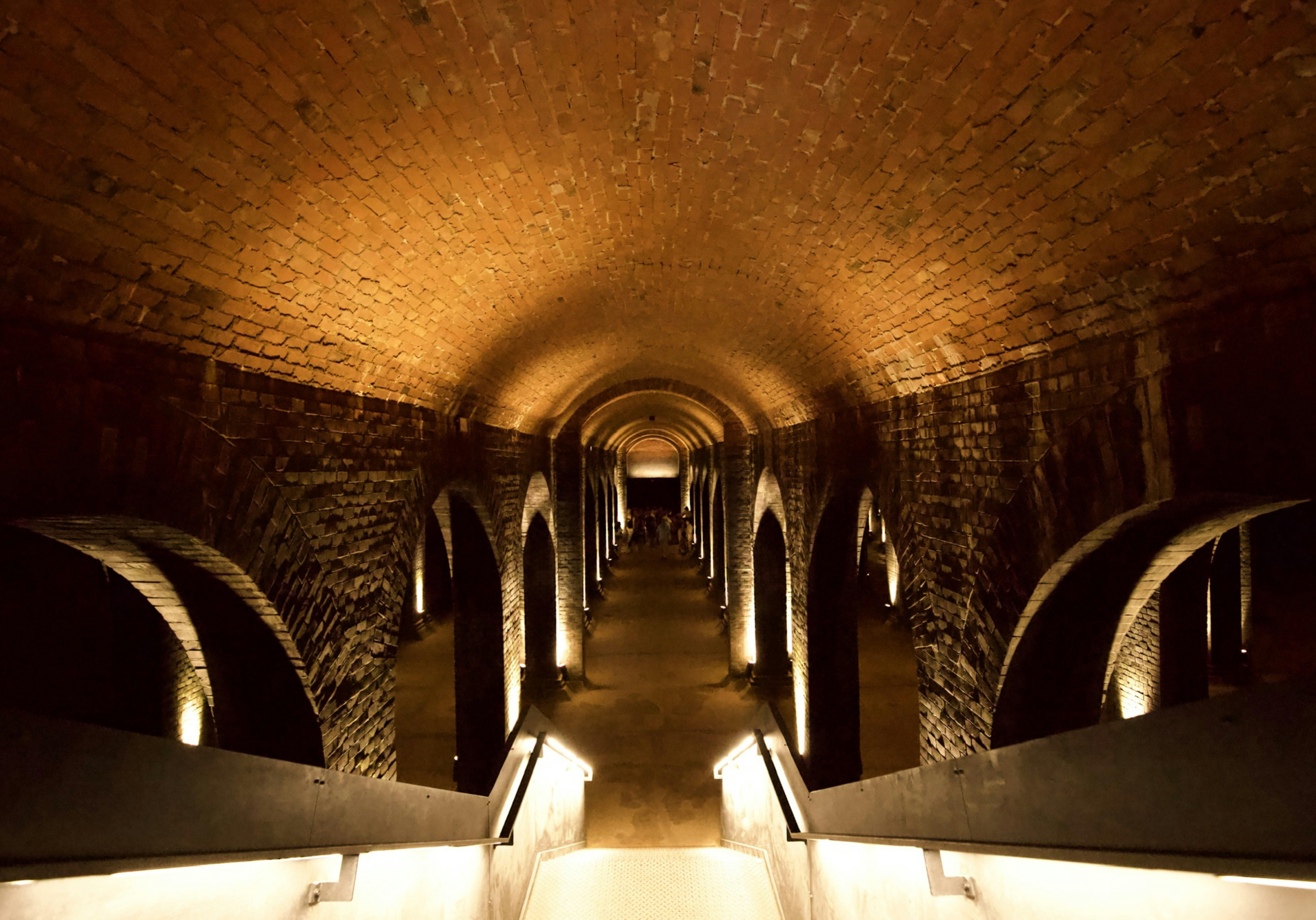 Long Staircase Through a Glow-Warmed Brick Tunnel
