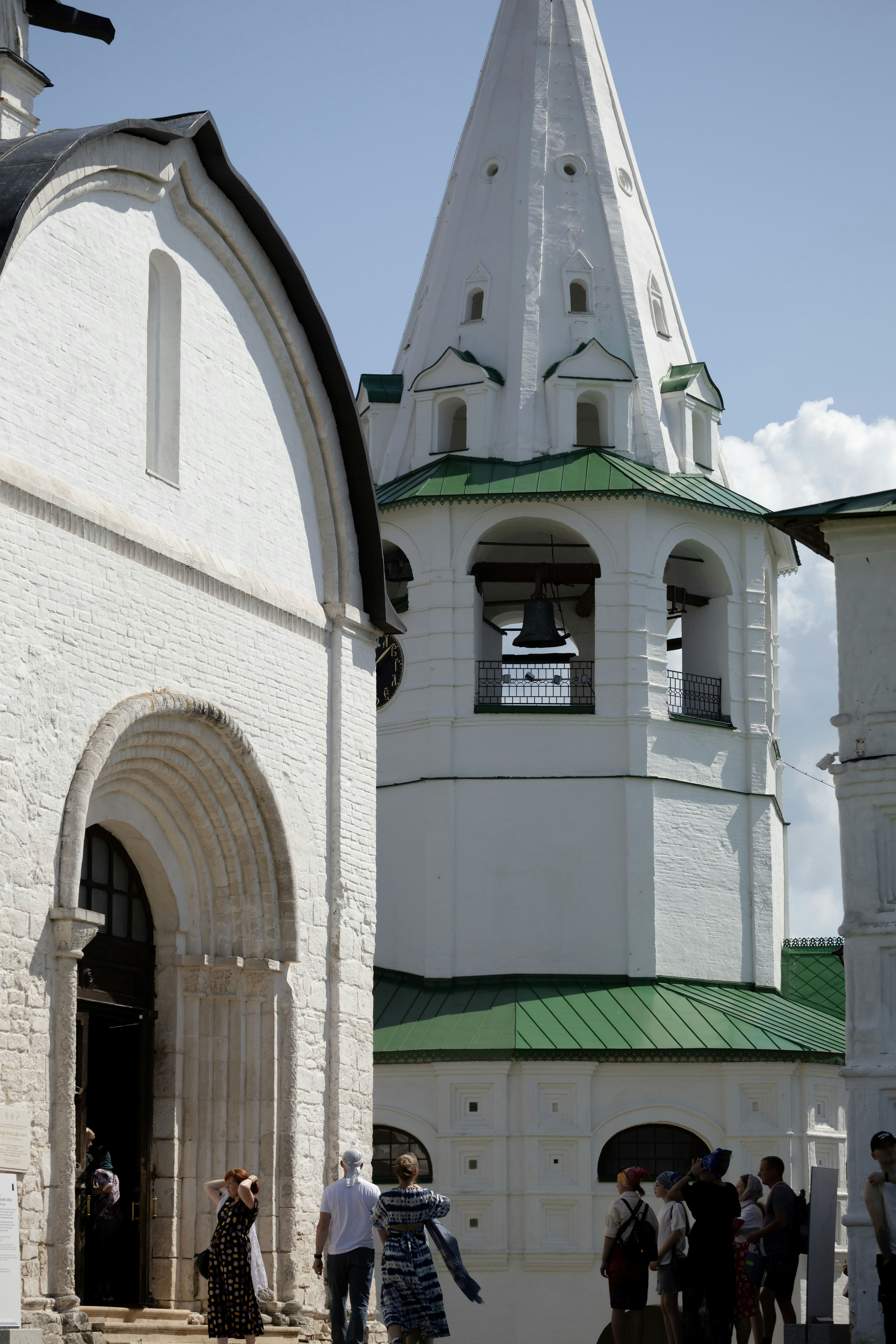 Basilica Bell and White Towers: A Moment Among Courtyard Visitors