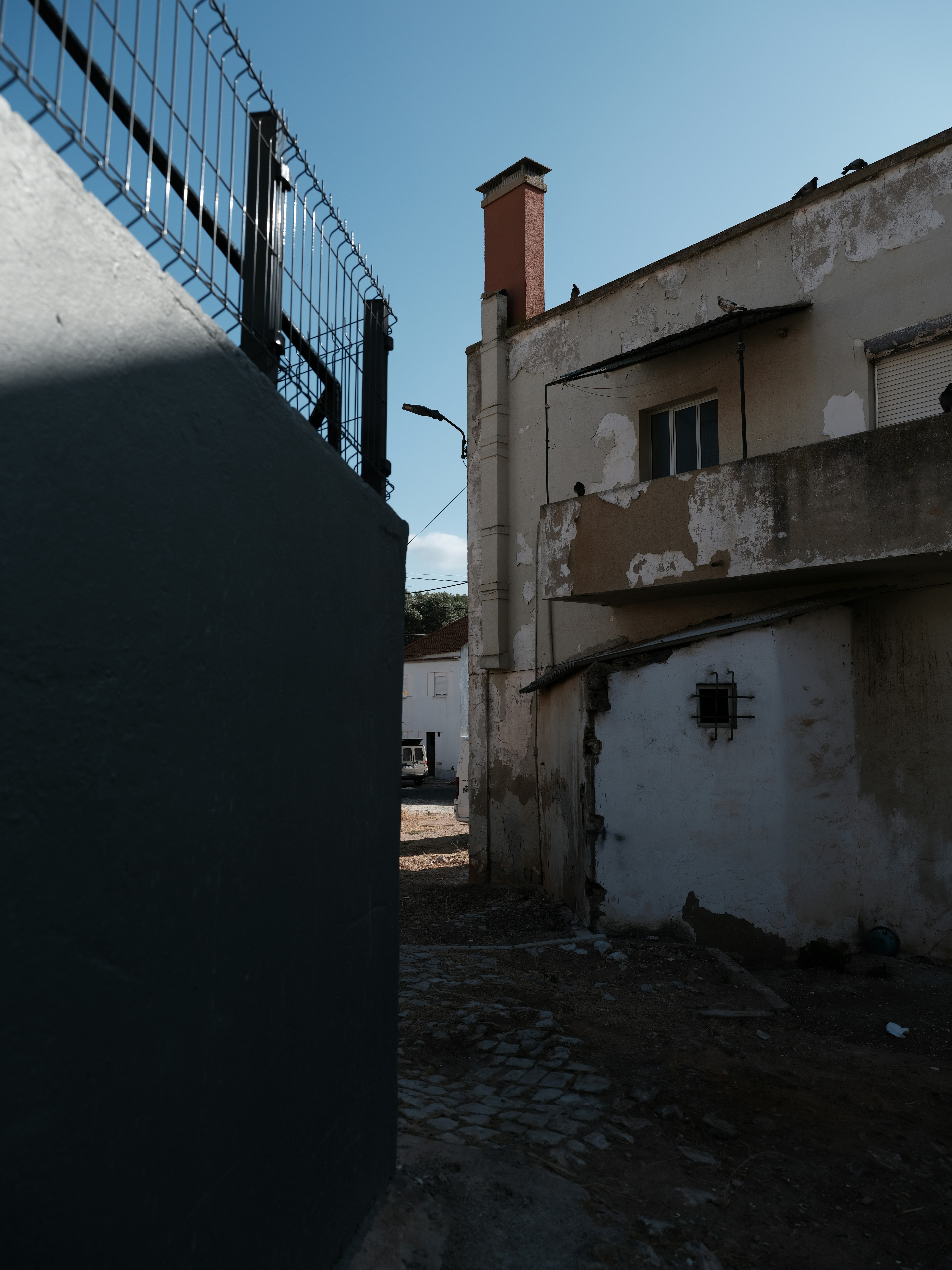 Between Two Walls: Narrow Lane to a Weathered Building