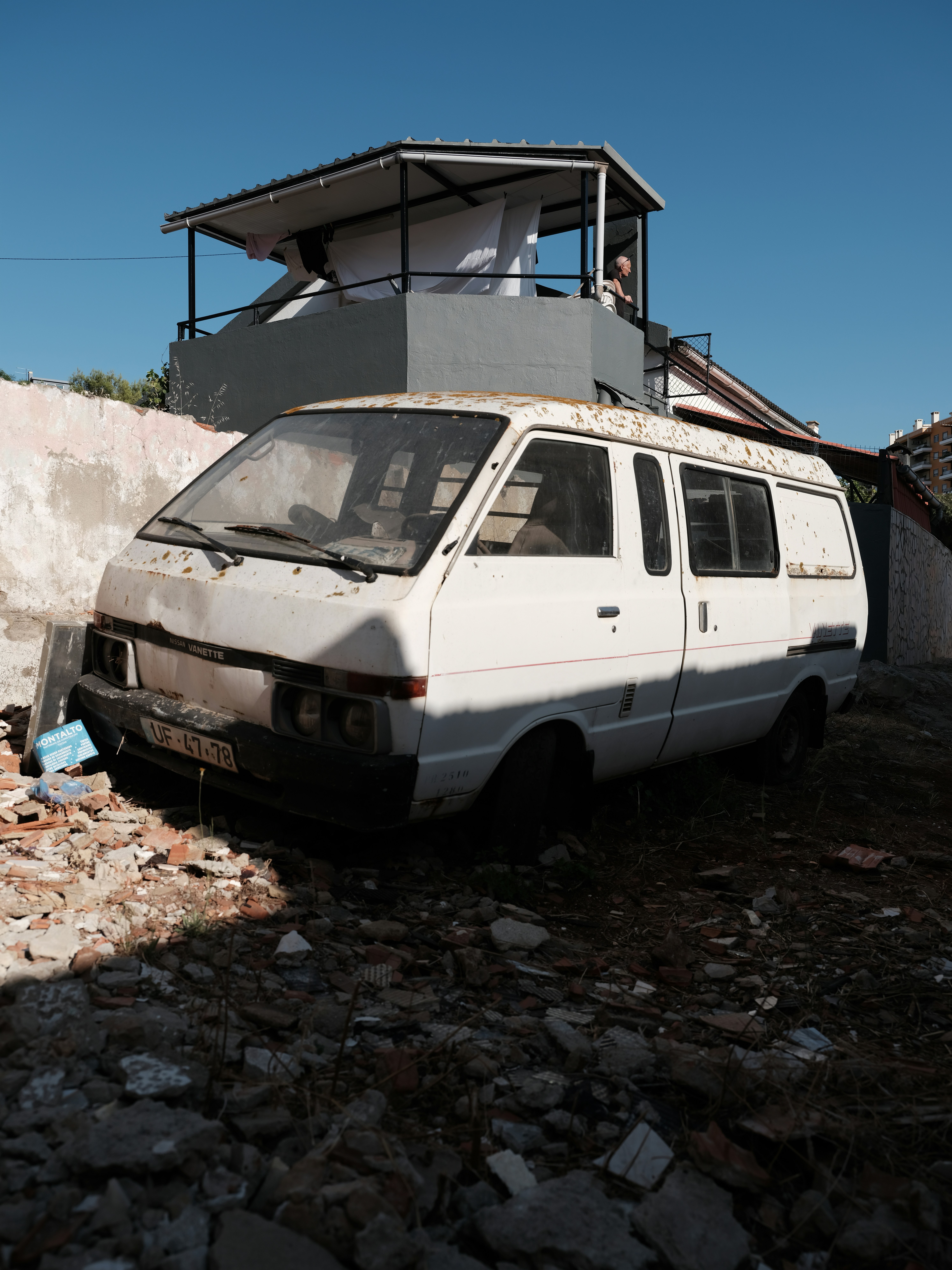 Dusty Van Under a Rooftop Shelter