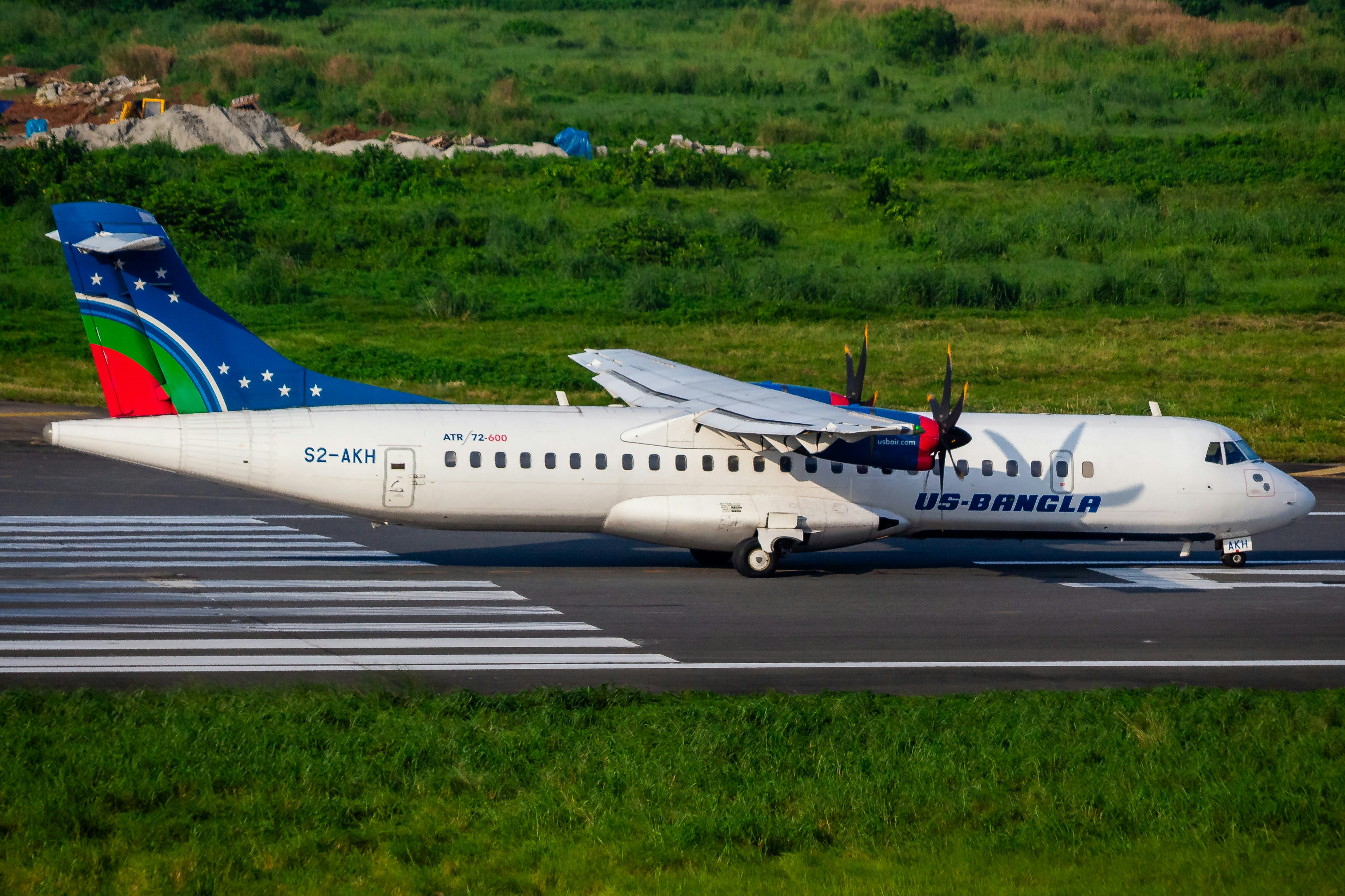 Colorful turboprop at rest on a striped runway