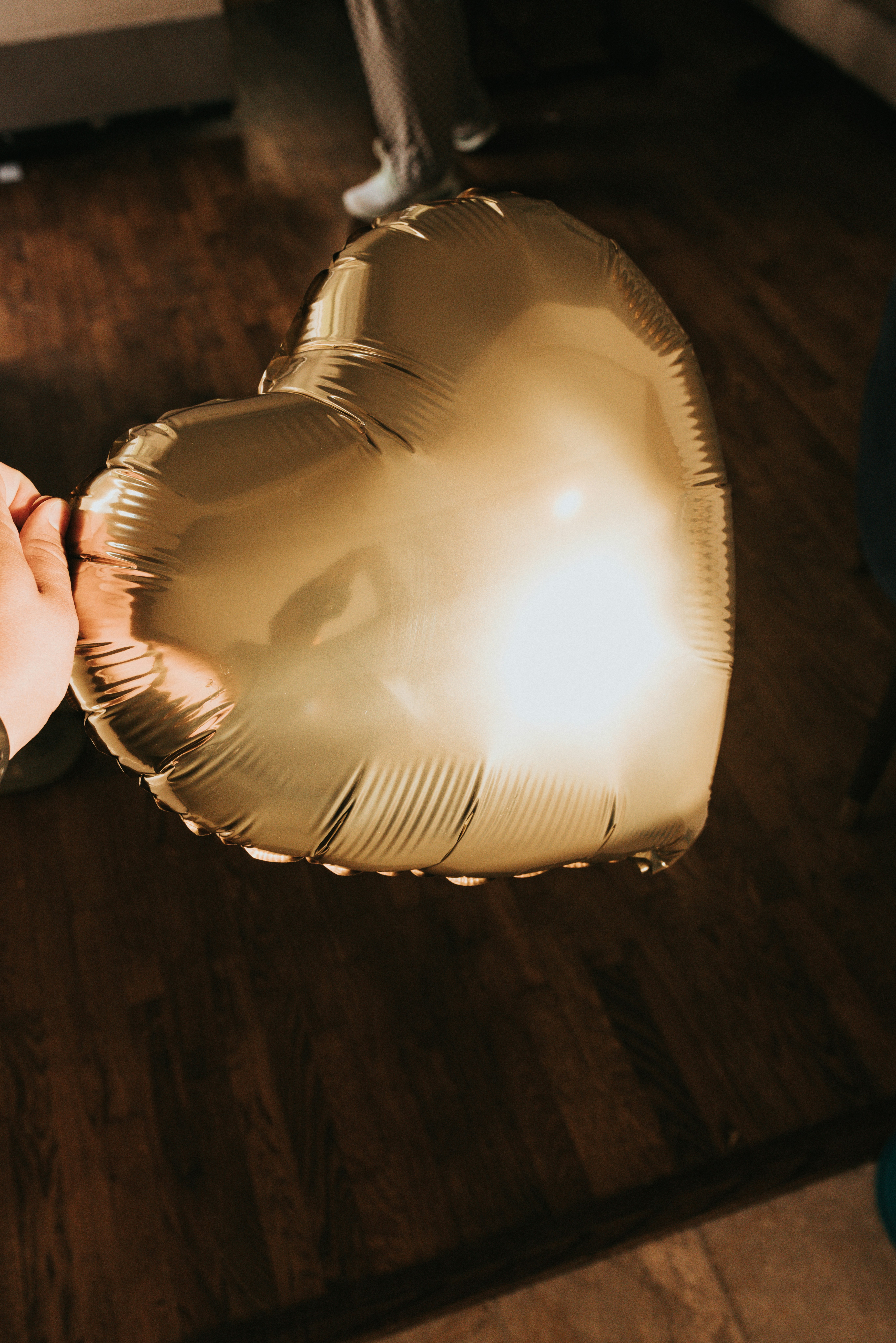 Heart in Hand: A Shiny Balloon Shared in a Dim Room