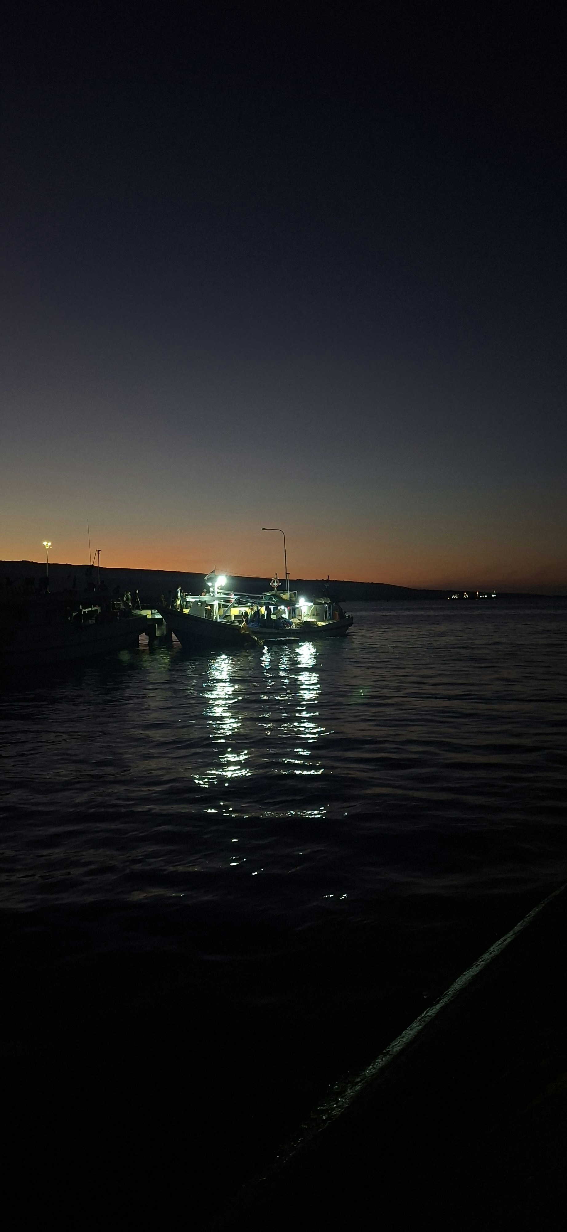 Dusk Harbor Lights: Boats Rest Along a Quiet Marina