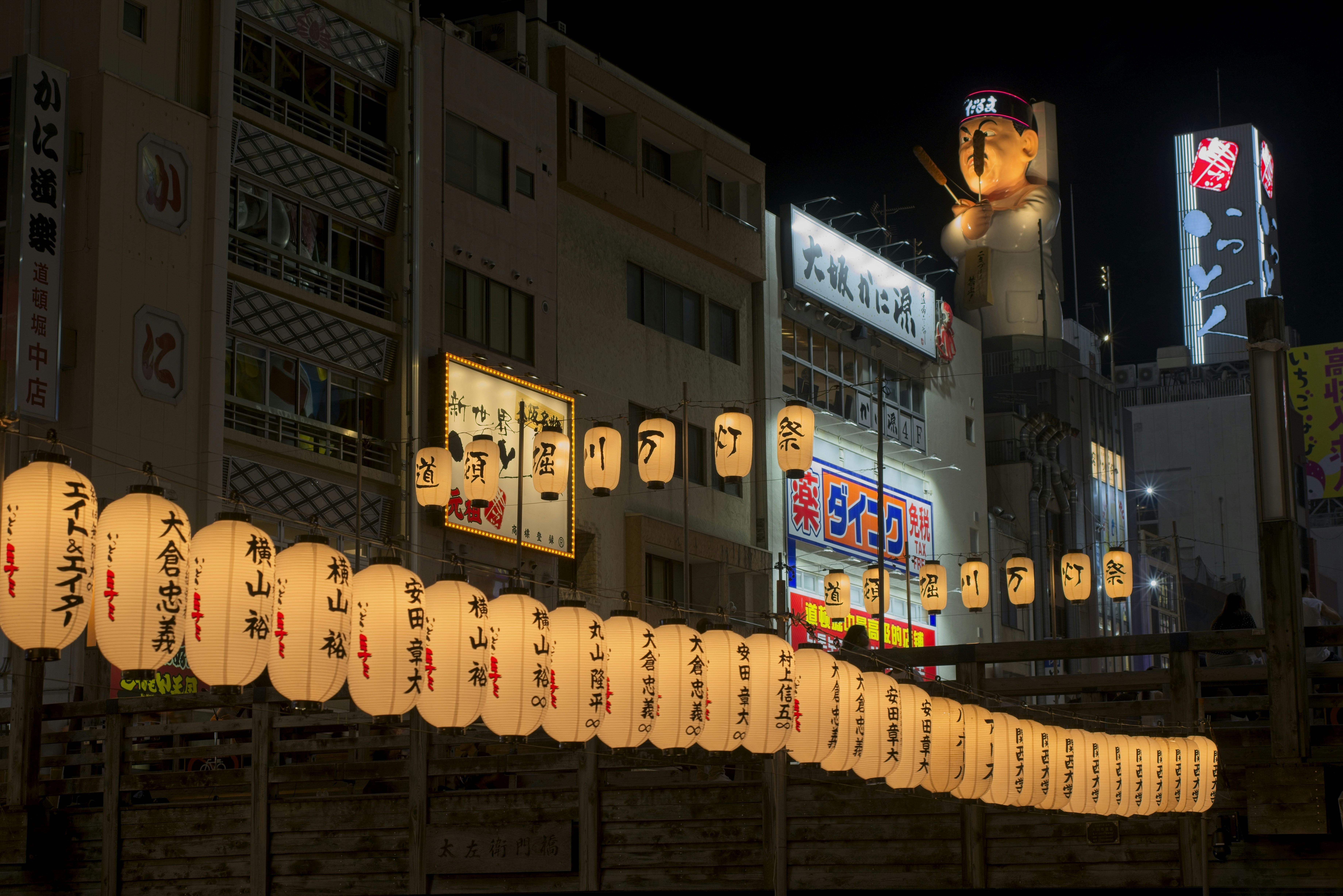 Lantern Corridor Under Neon Giants