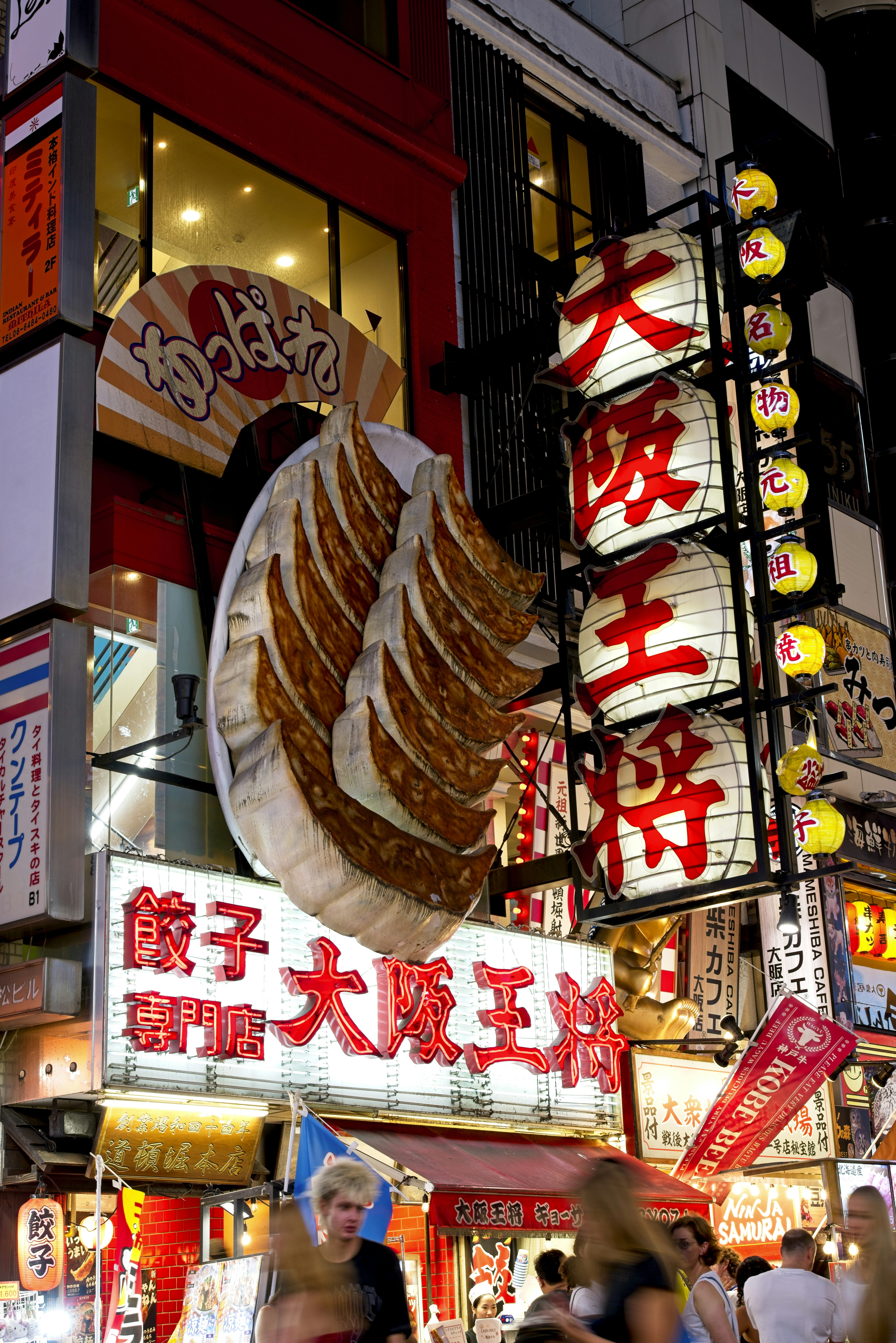 Giant Gyoza Signage Looms Over Bustling Osaka Night Market