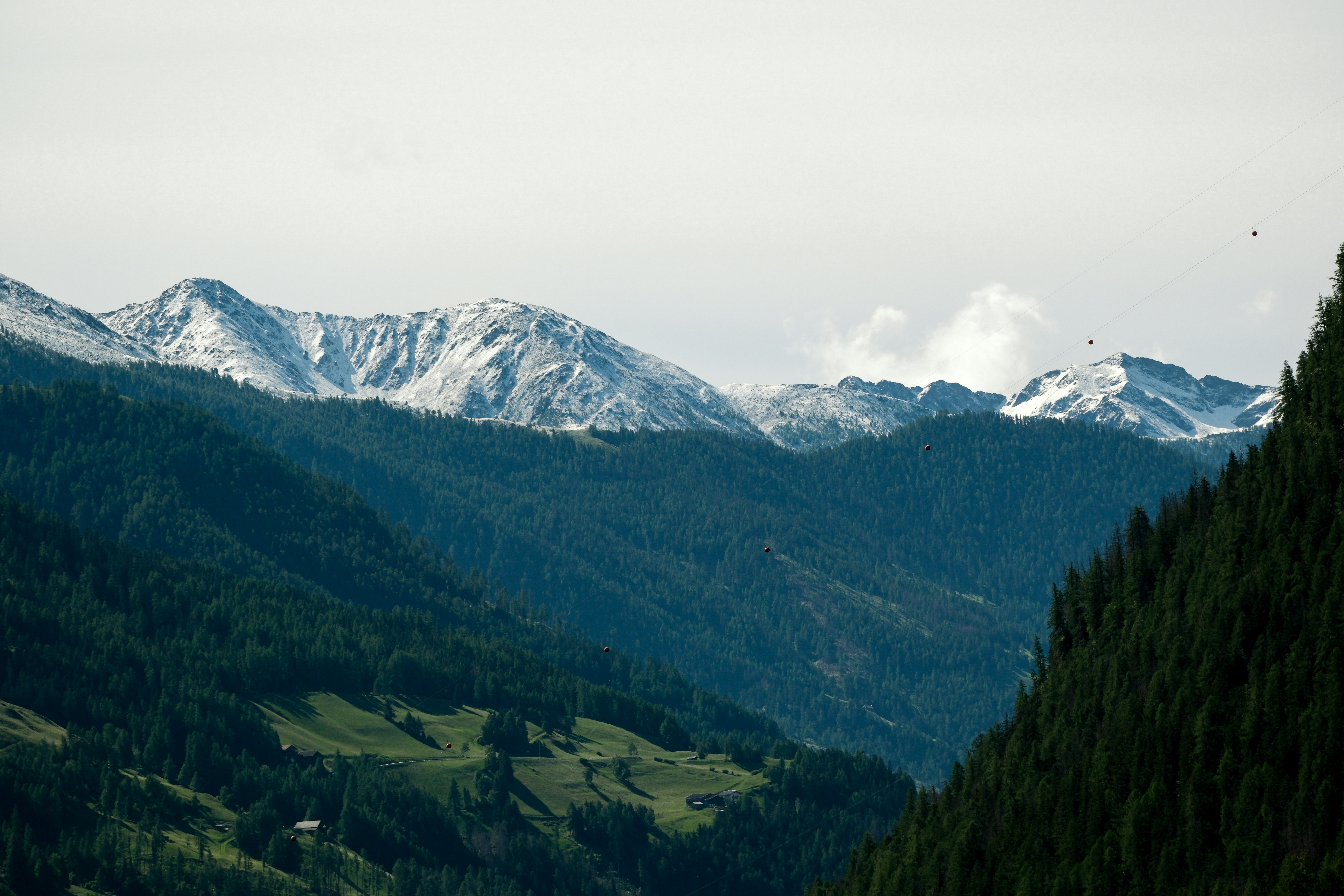 Snow-kissed ridge over verdant valley
