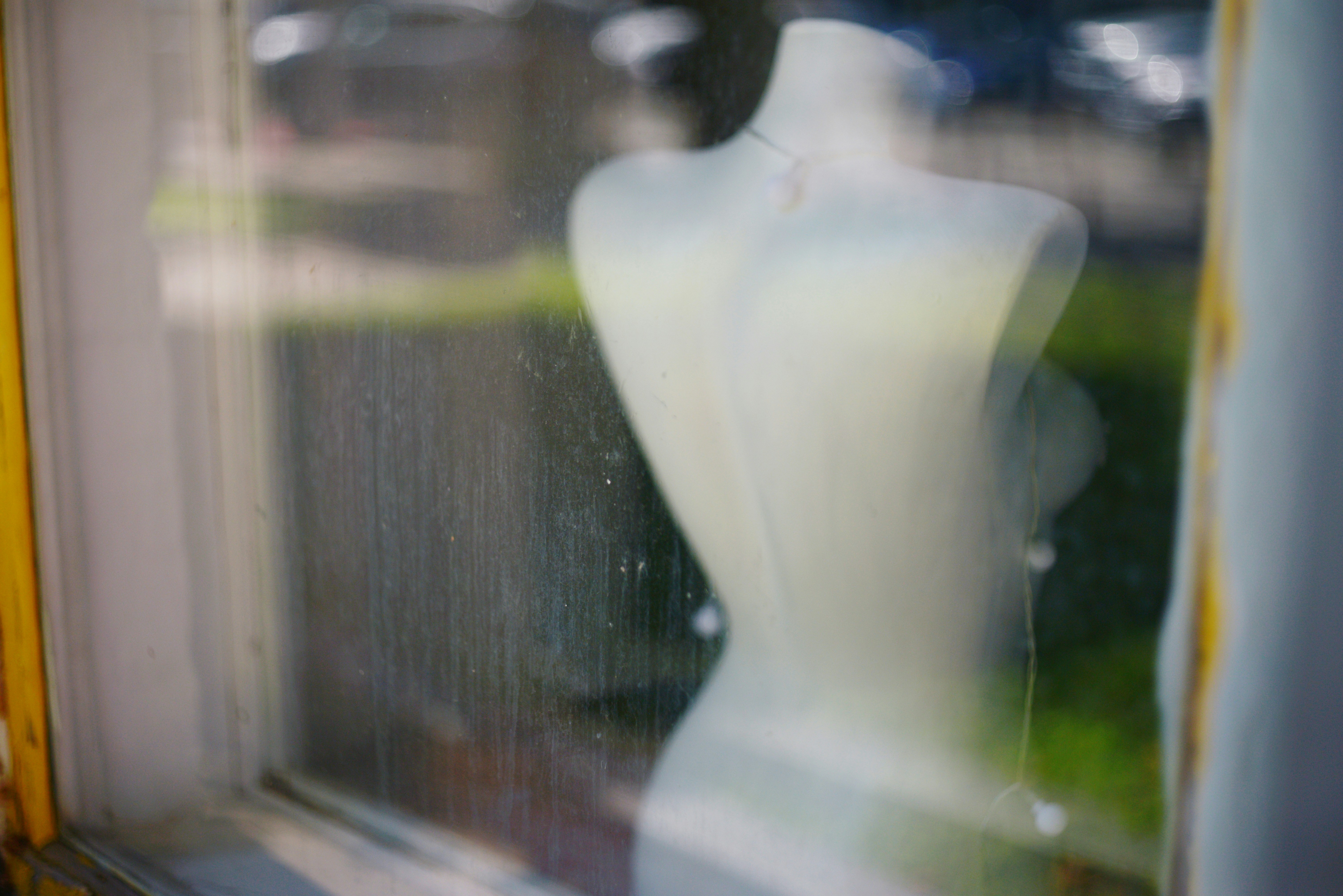 Blurry mannequin silhouette reflected in shop window
