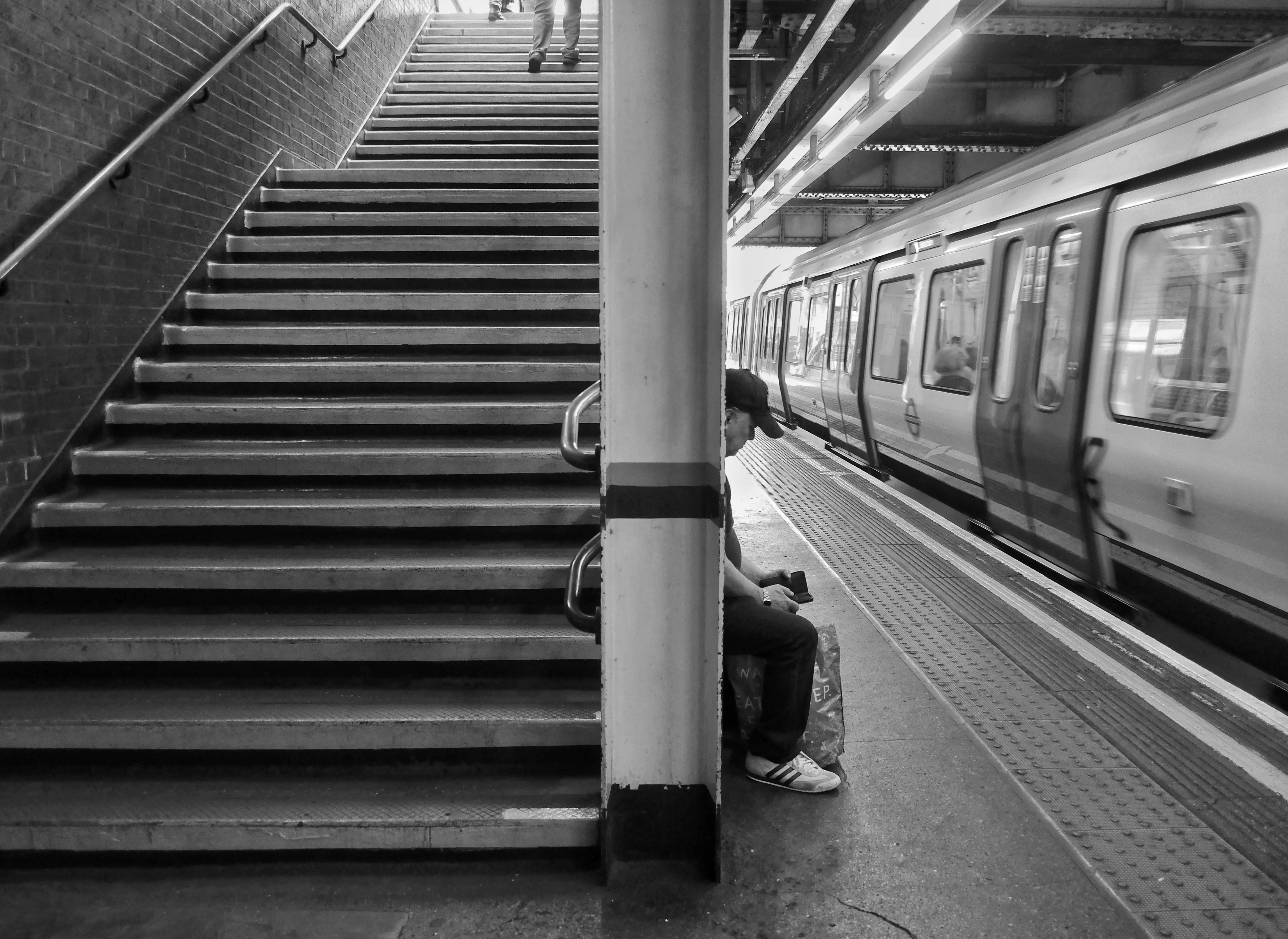Platform Silence: A Passenger on Pause Under the Subway Shroud