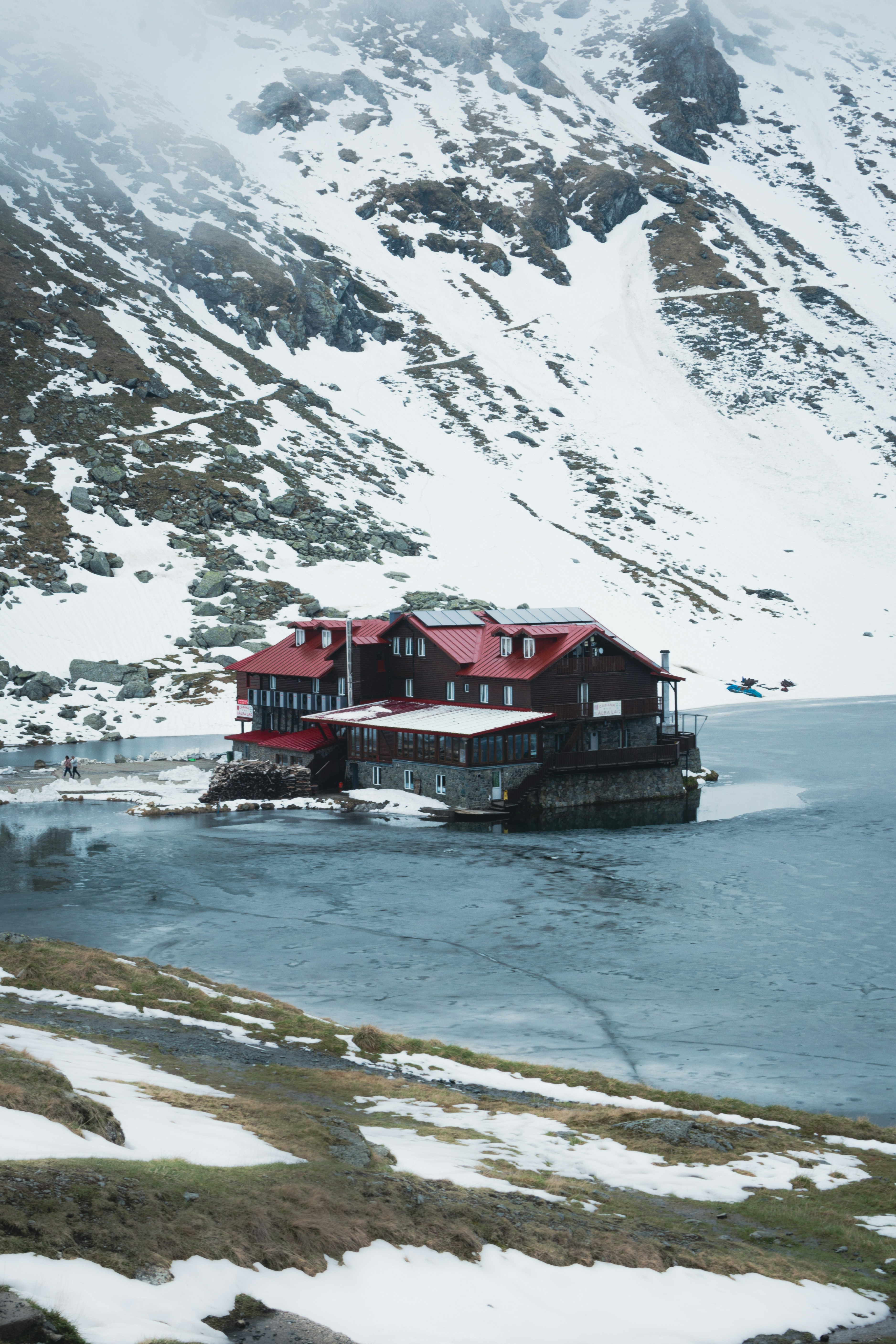 Snowbound Retreat: A Red-Roofed Haven afloat in a glacial sea