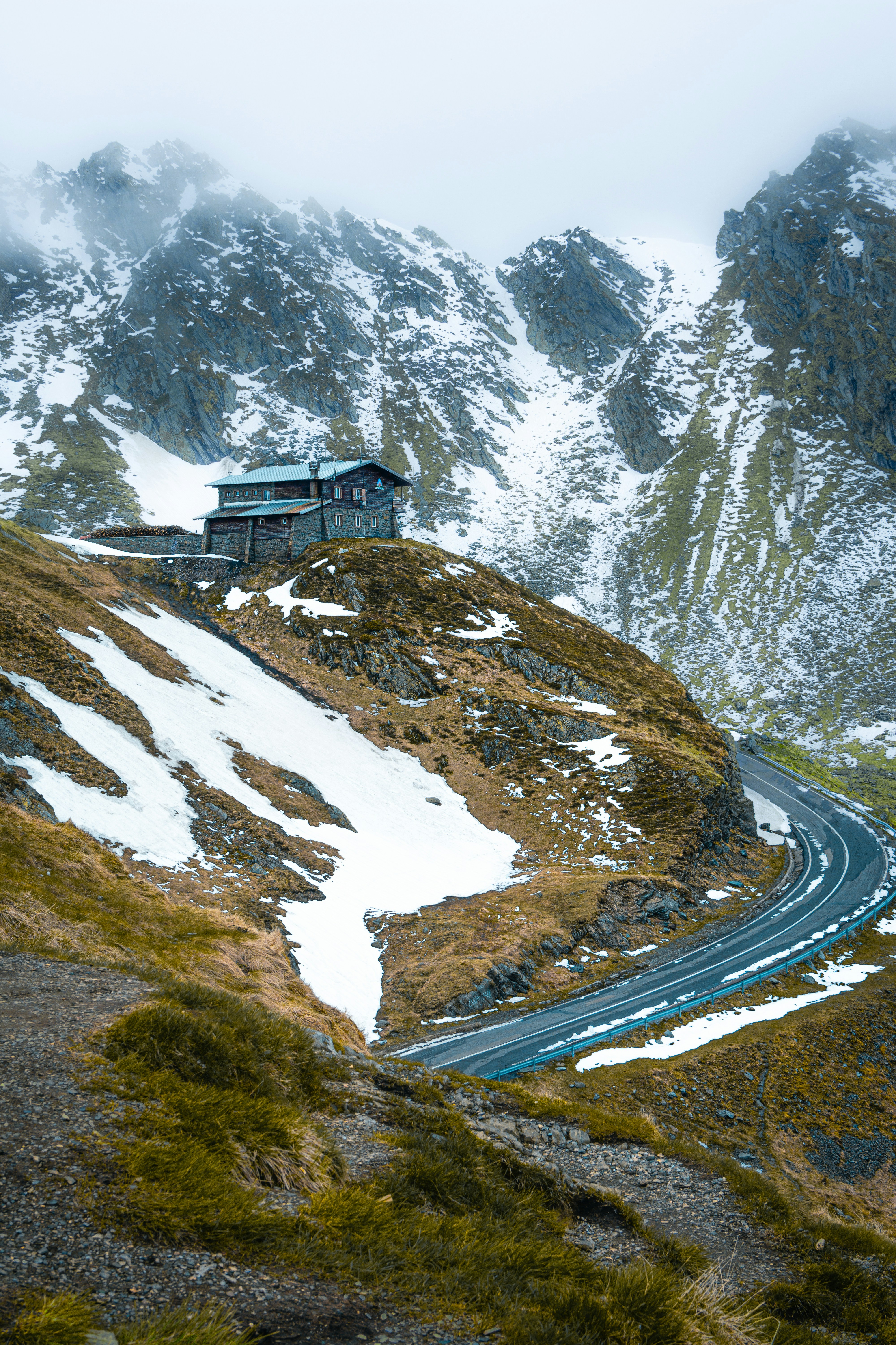 Mountain Lodge Haltingly Wears the Curve of a Snow-Washed Pass