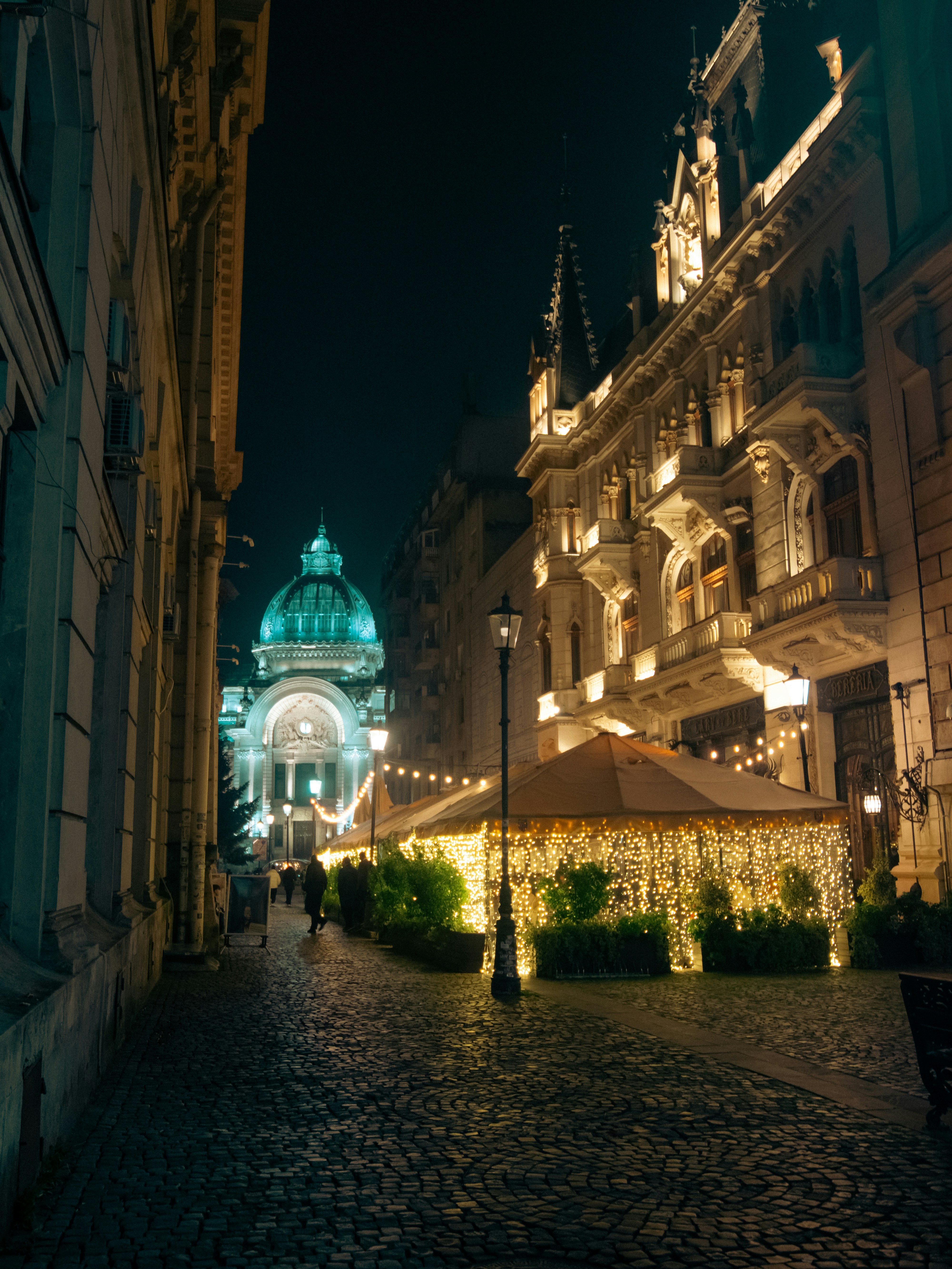Cobbled Night Arcades Lead to a Neon Church Dome