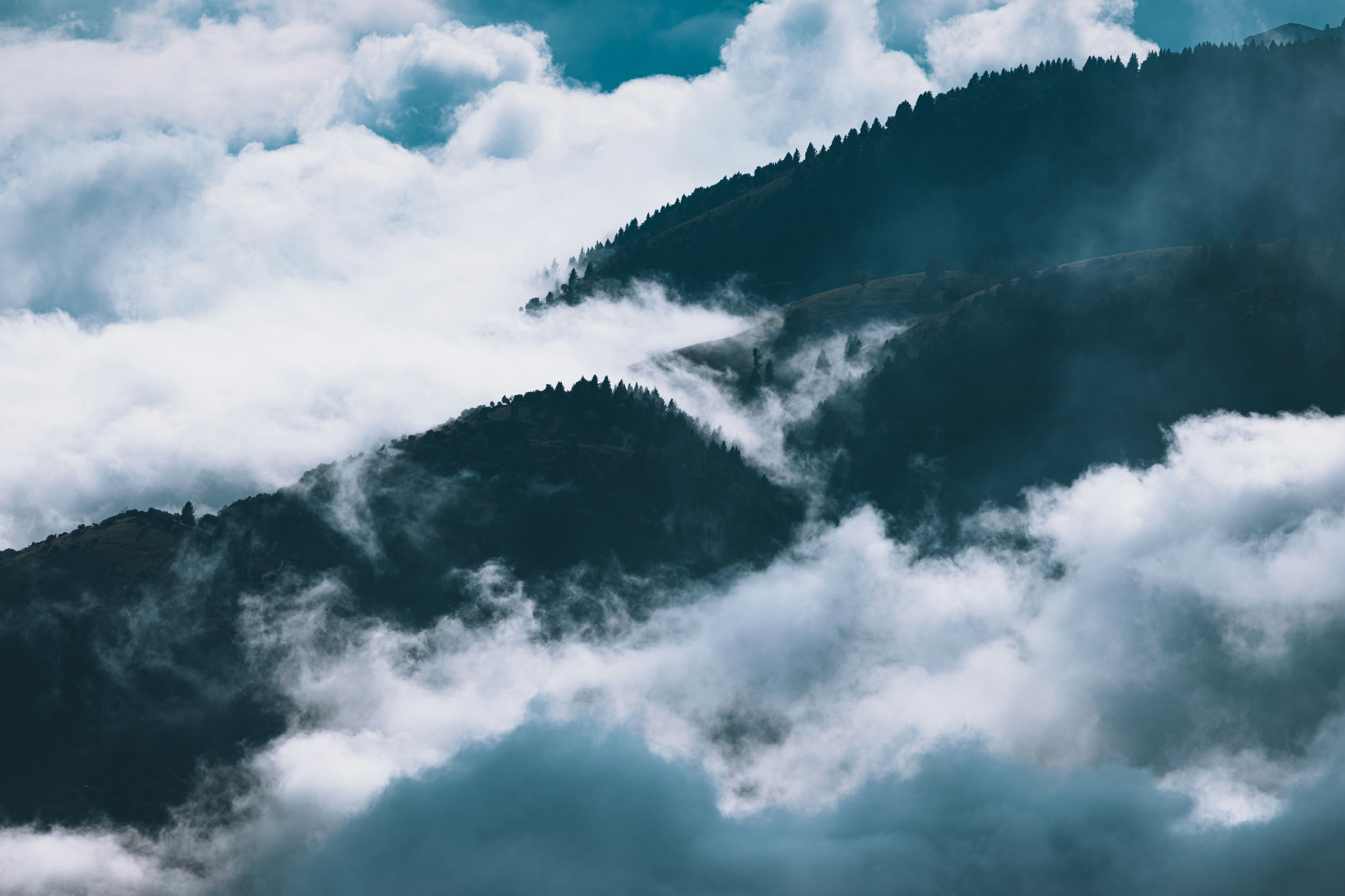 Mist-kissed ridge: sunlight slips over cloud-veiled peaks