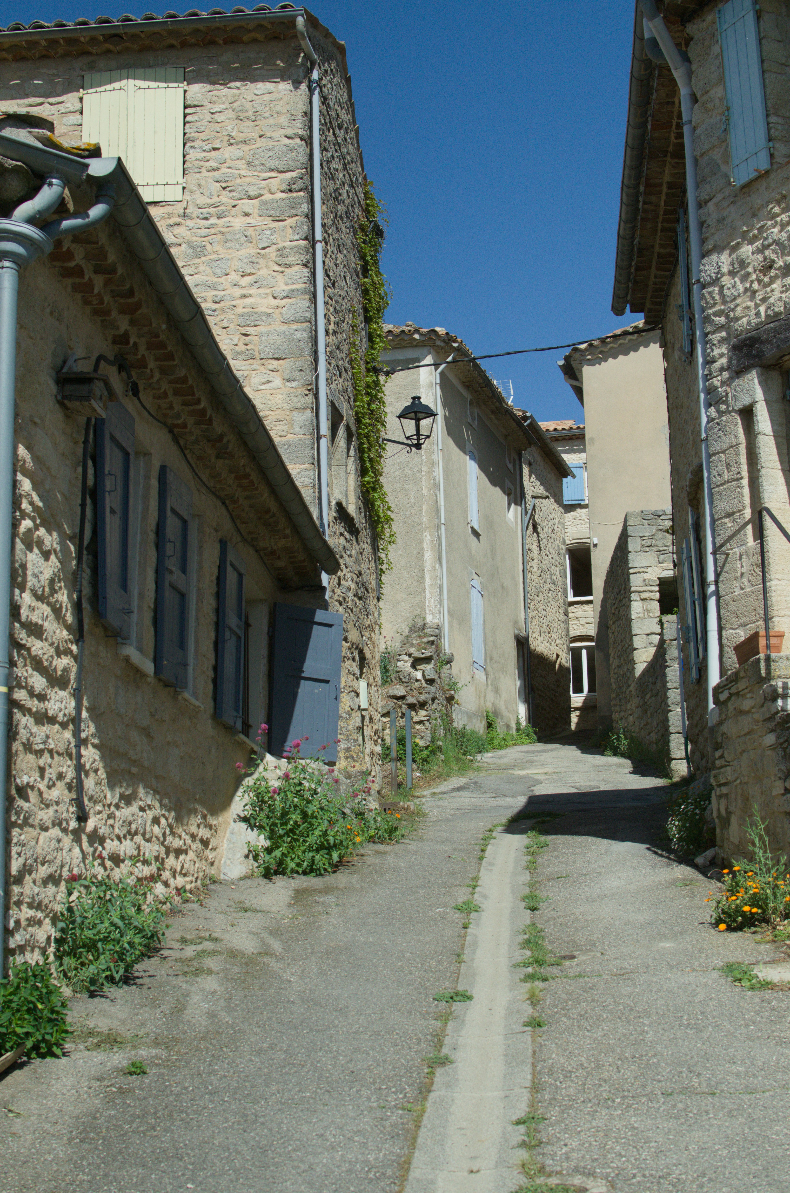 Sunlit stone alley: Old-world charm vanishing into light