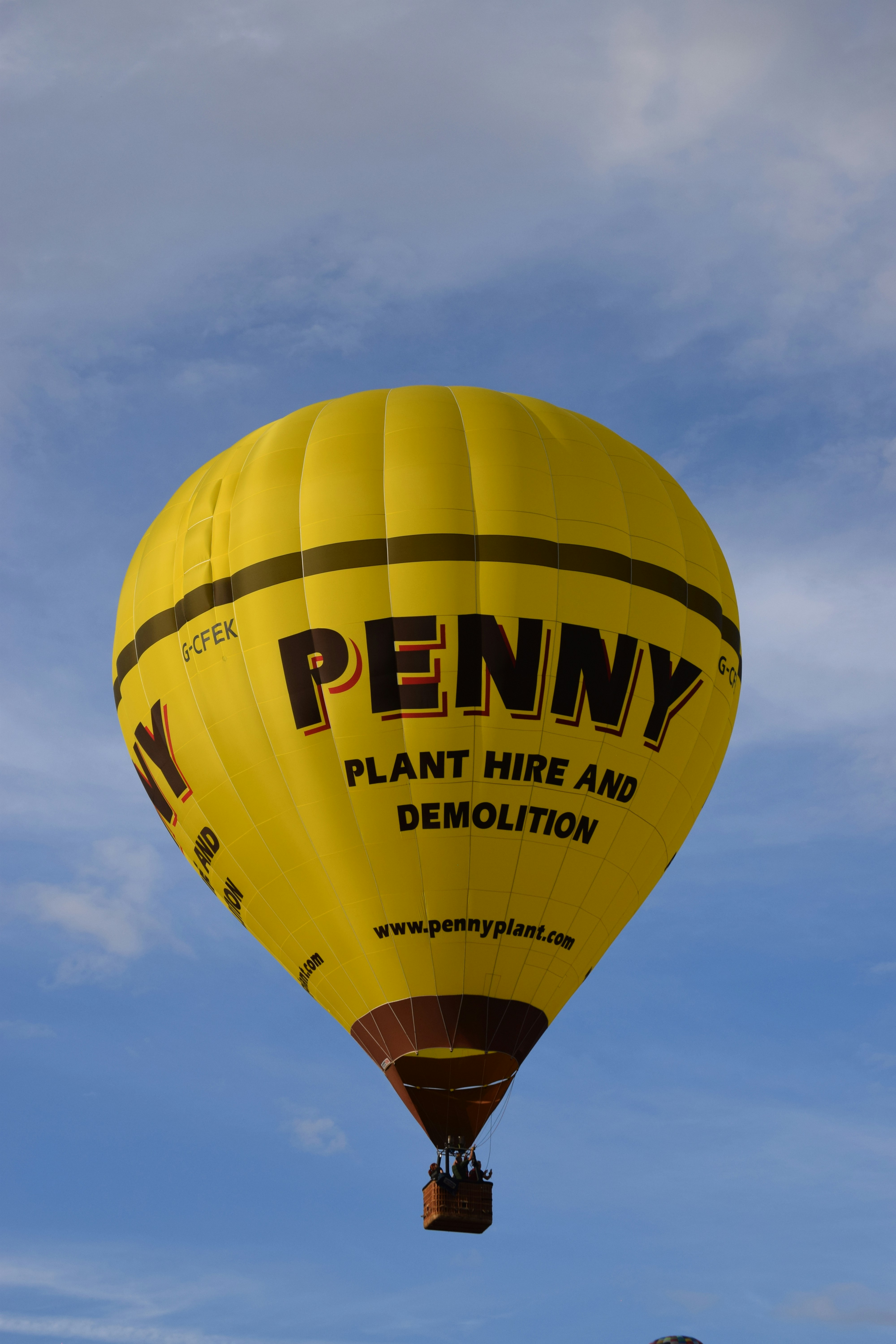 Yellow Penny Balloon Soaring Over a Calm Blue Sky
