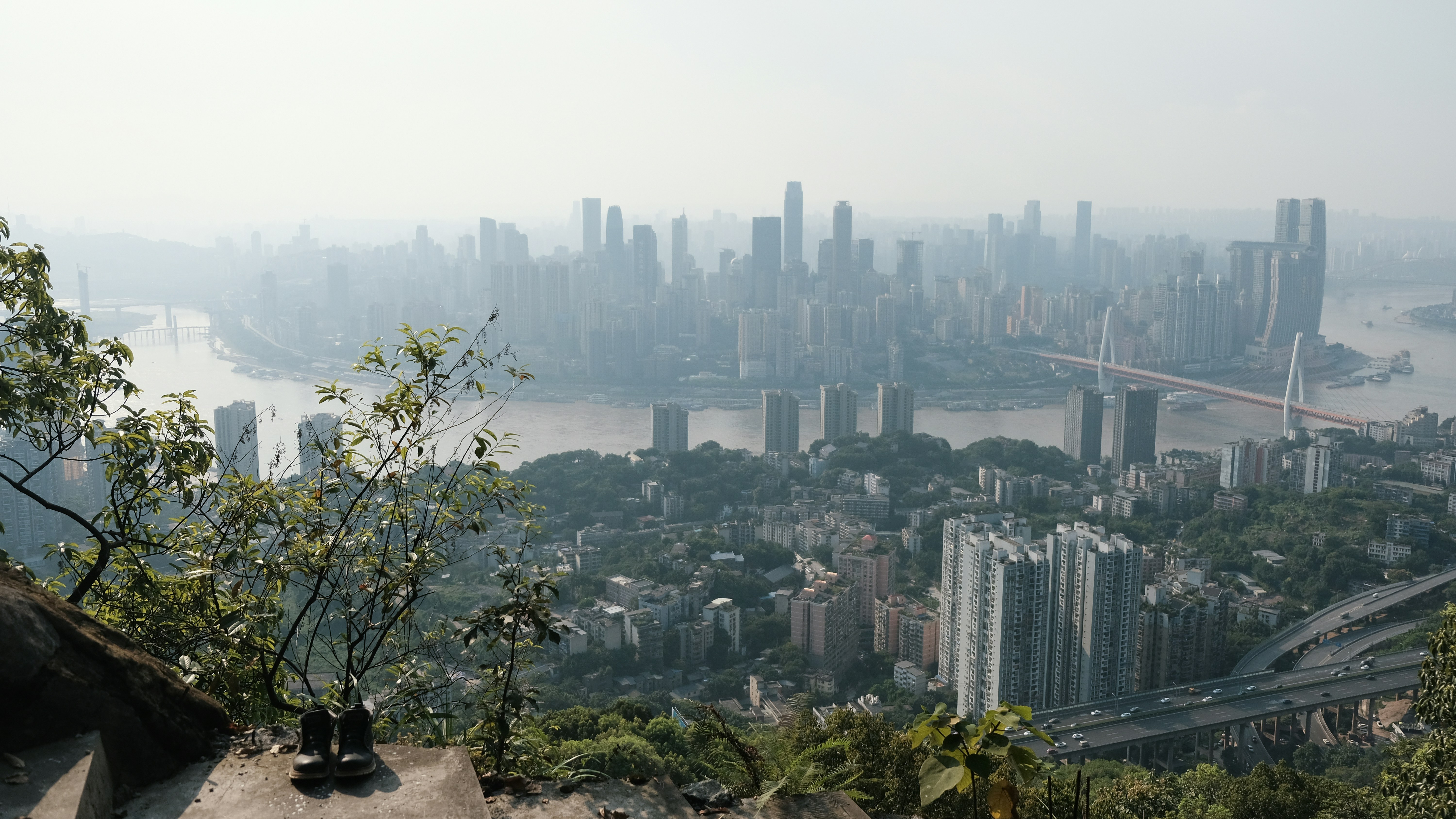 Cityscape Aglow: A High-Altitude View Over a Hazy River Metropolis