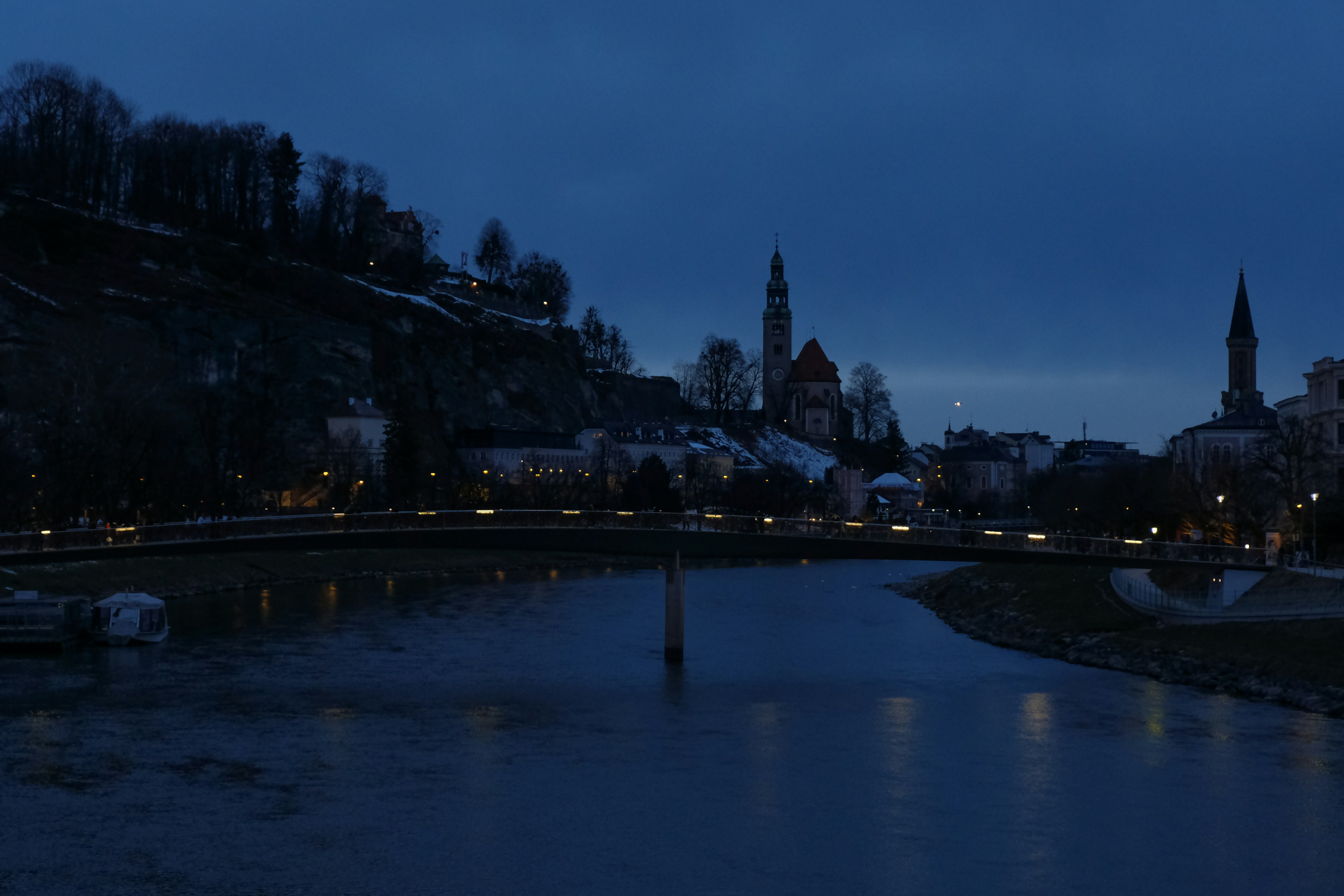 Silent Riverbank at Dusk: City Lights Bleeding Into the Night