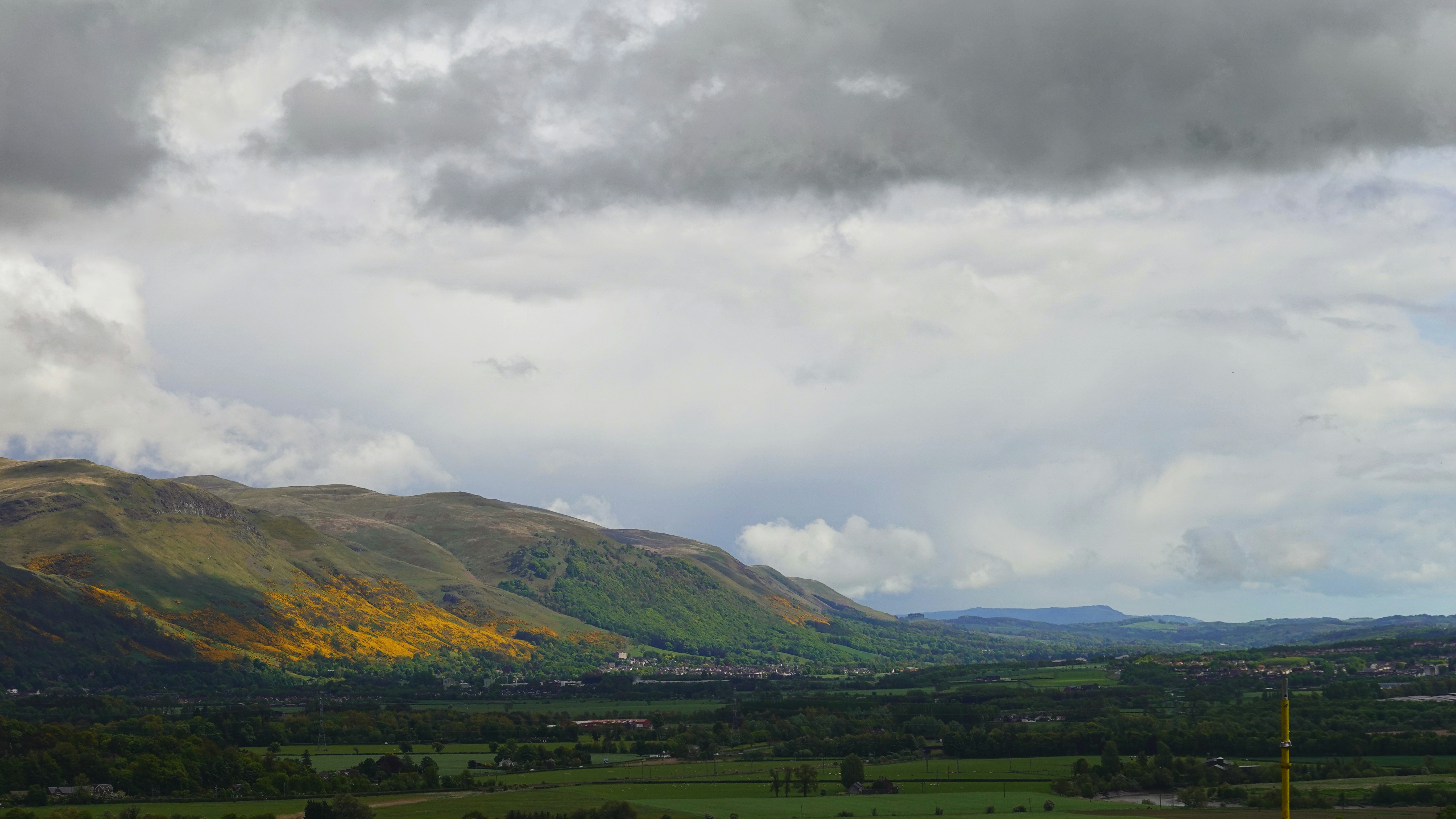 Golden Hills Under Layered Clouds