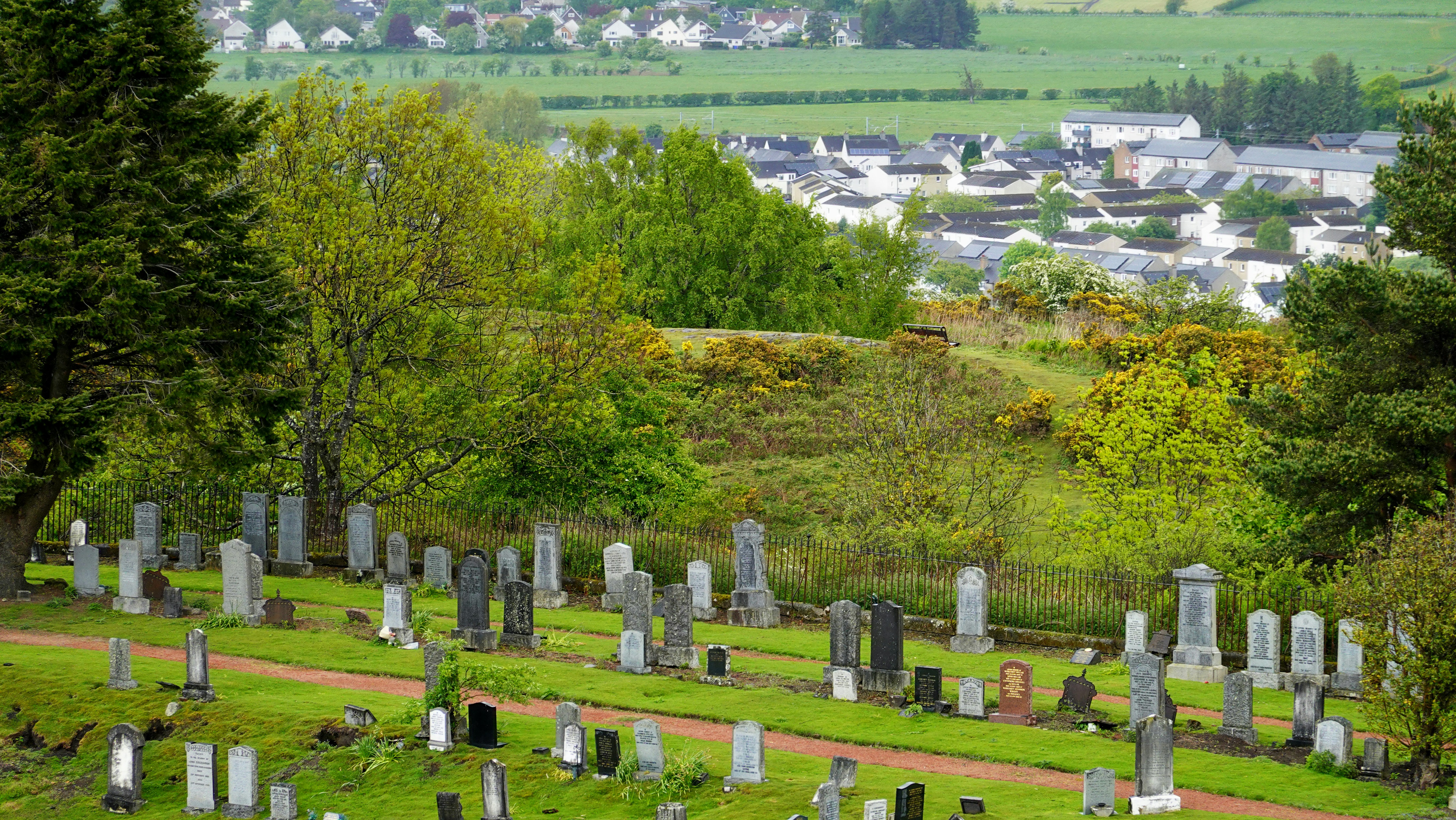 Rows of memory: a tranquil cemetery beneath a village panorama