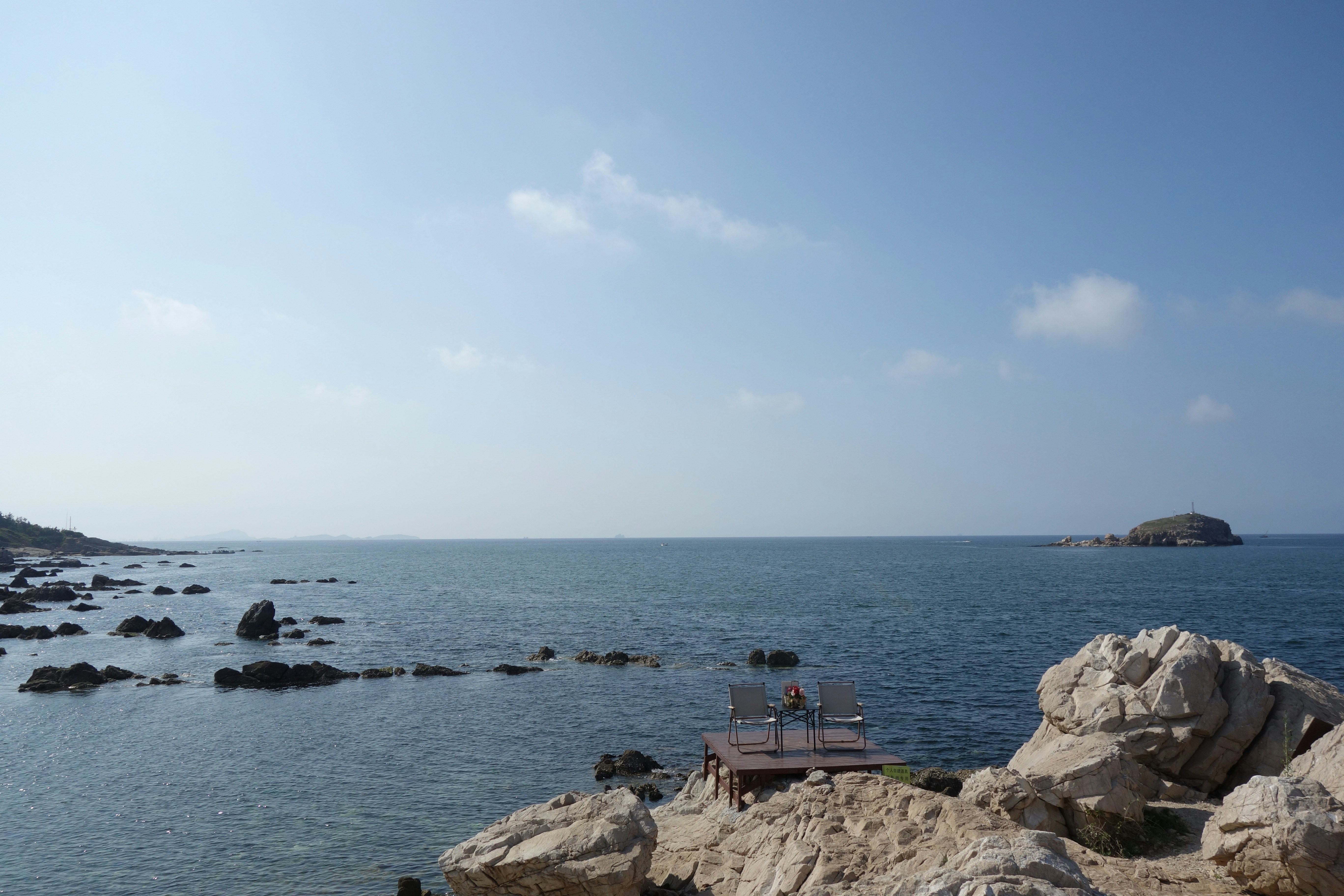 Rocky shoreline rendezvous at sea: a sunlit overlook