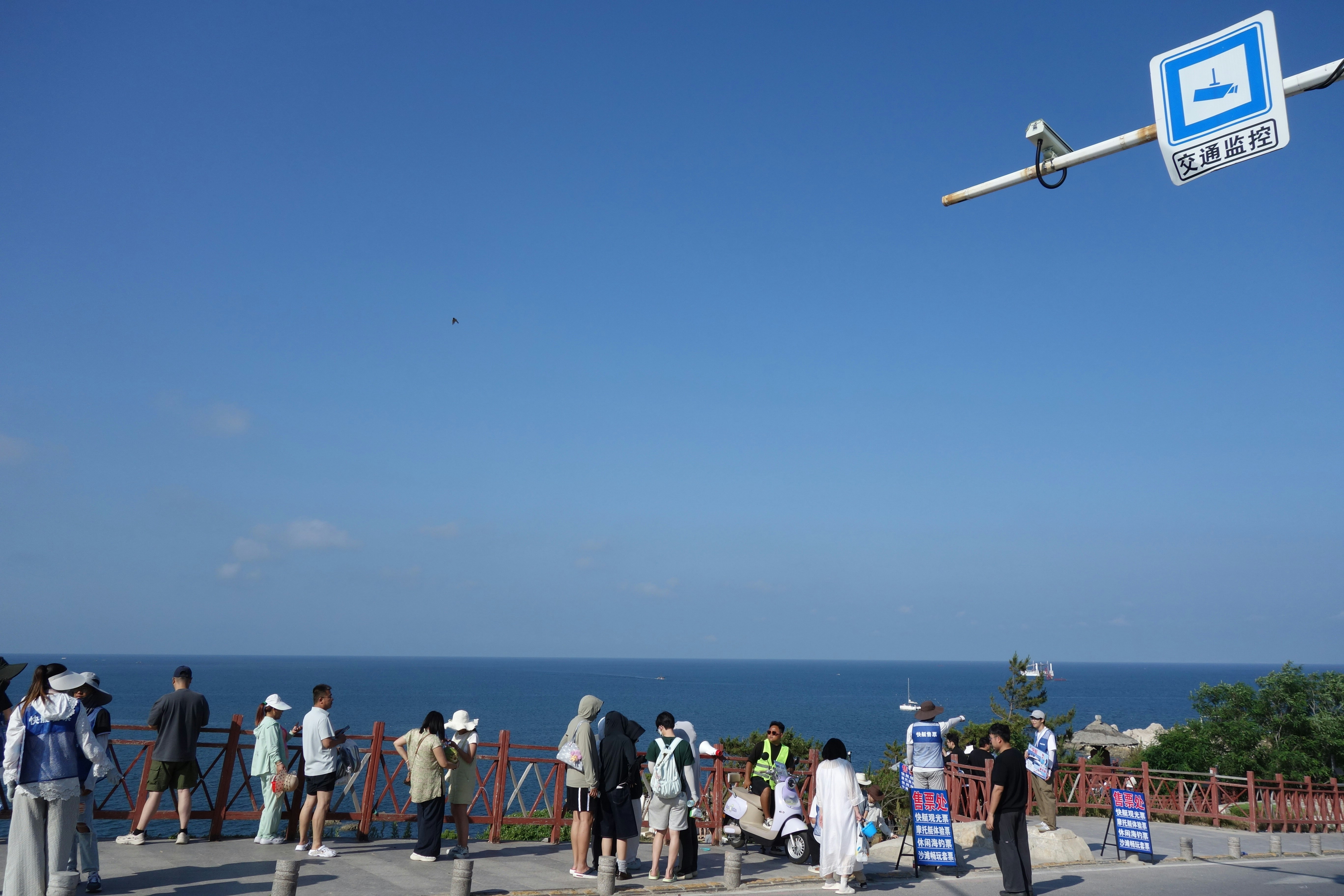 Clifftop Viewpoint: Tourists Gather for Ocean Breeze