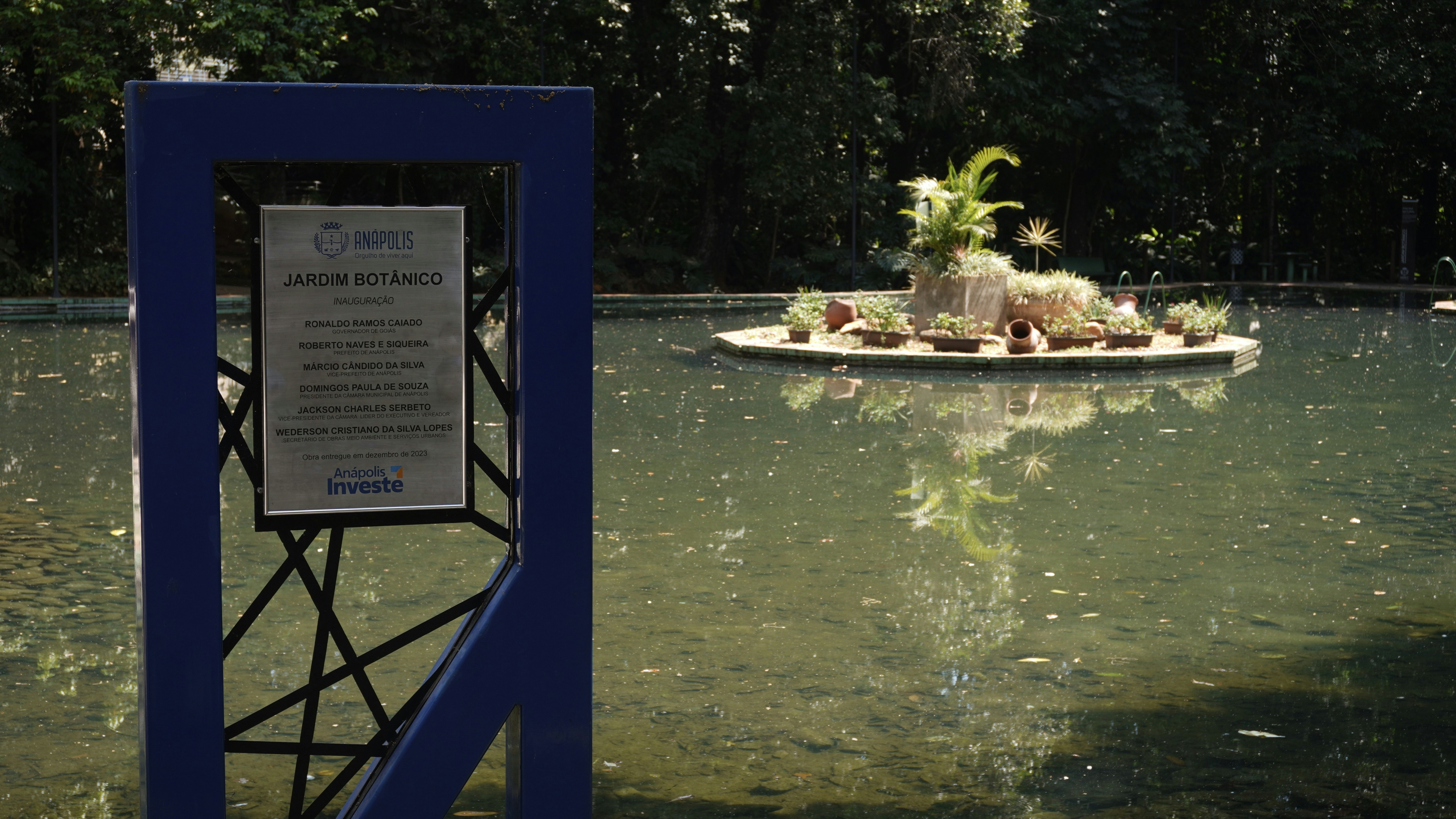 Blue Frame Sculpture Over Gentle Pond with Floating Island