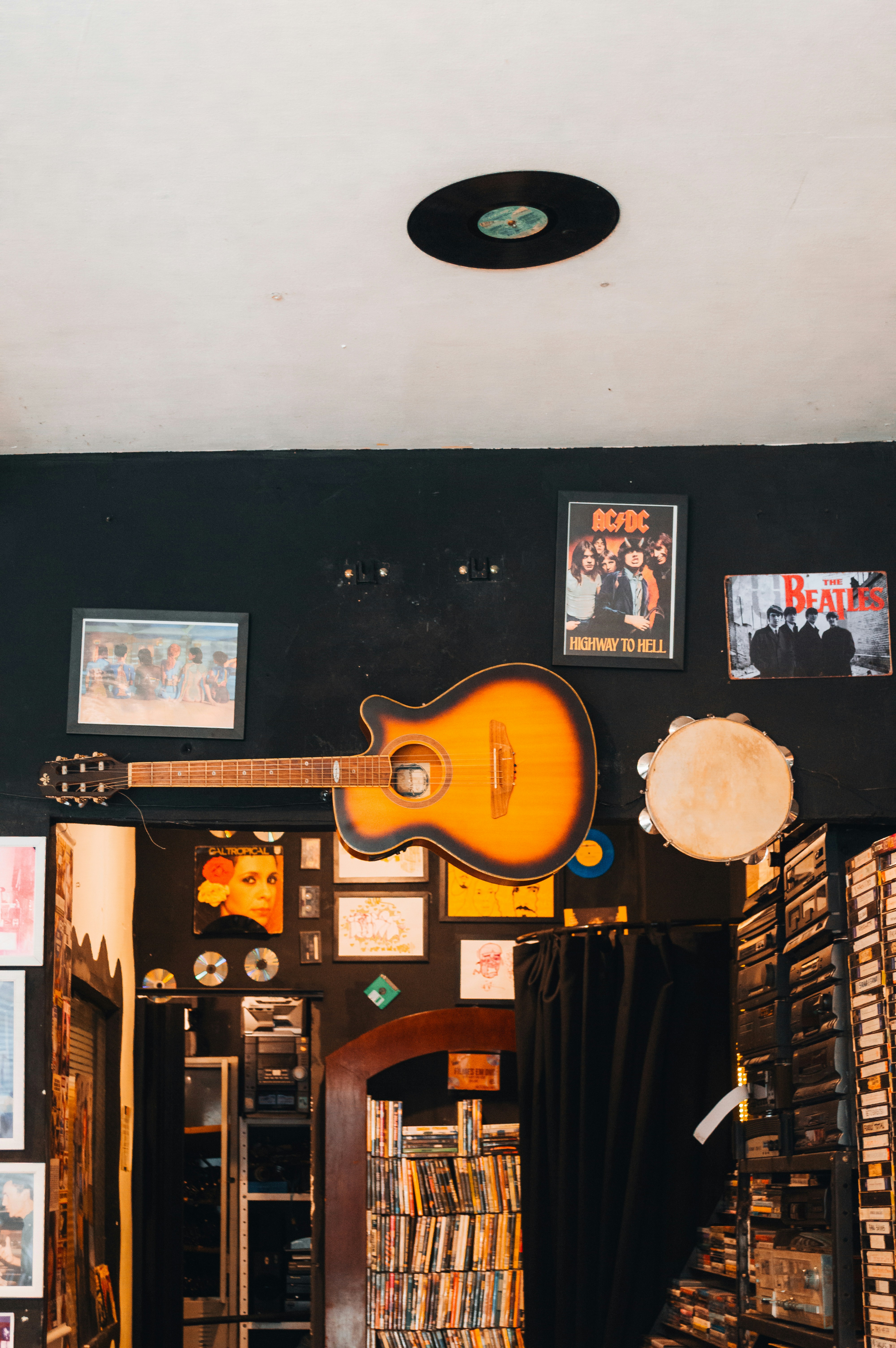 Acoustic Spotlight: The Guitar Hangs Above a Vintage Vinyl Gallery