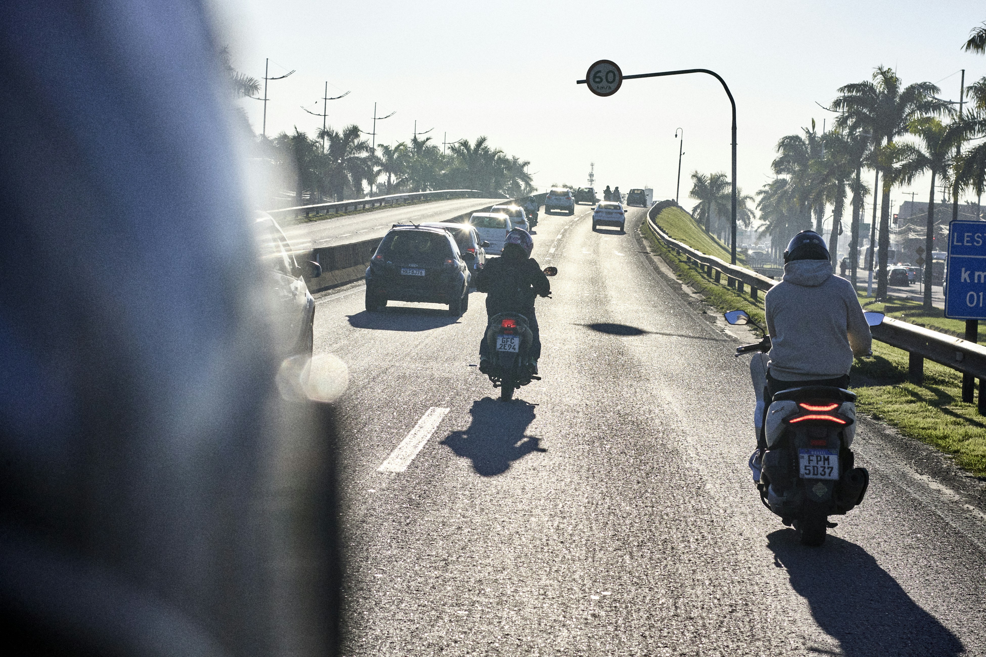 Coastal Highway Ride: Two Motorcyclists in Sunlit Traffic