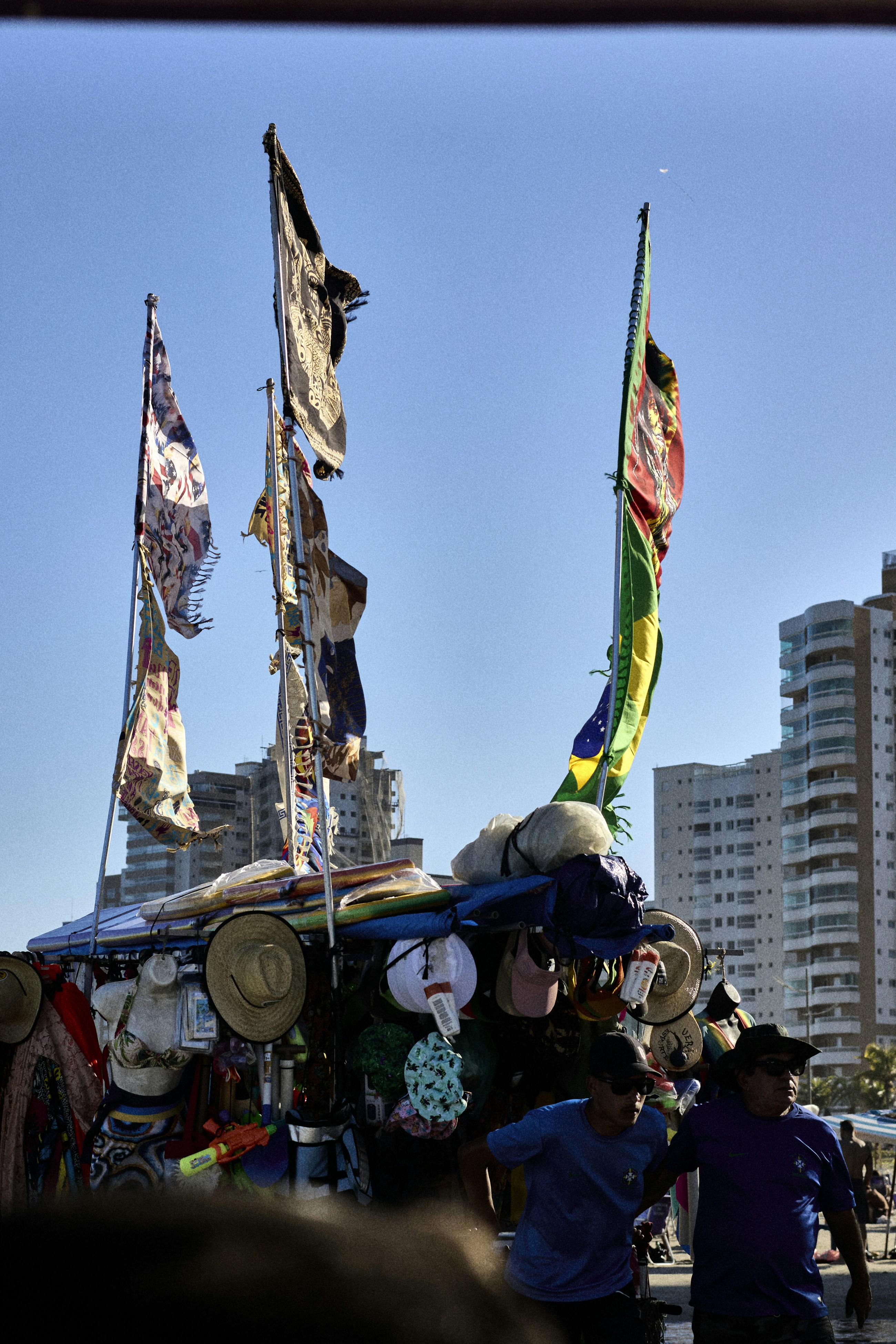 Colorful Flag Poles over a Bustling Street Vendor