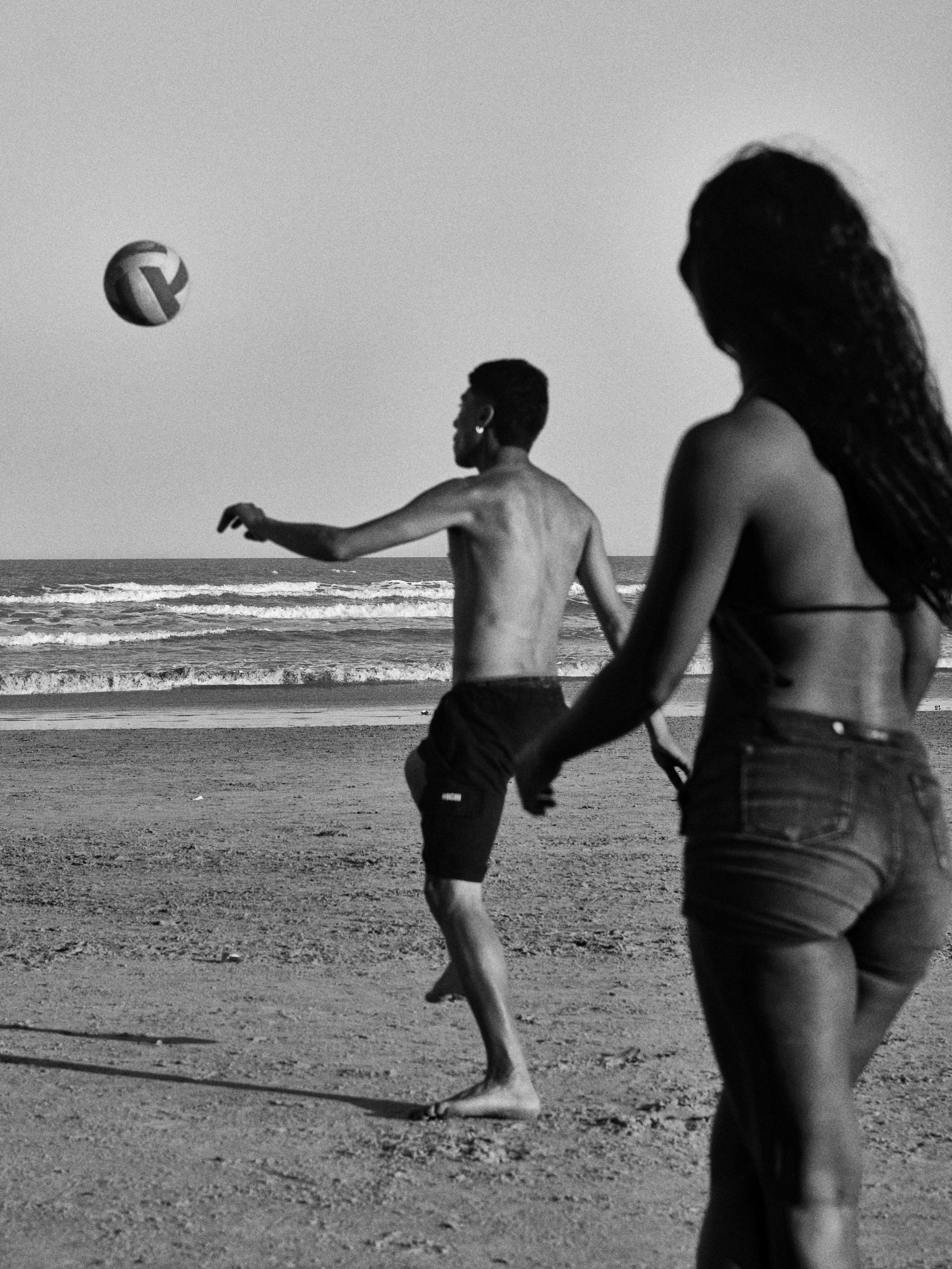 Beach Volleyball Moment: Two Players in Silhouette on a Sunny Shore