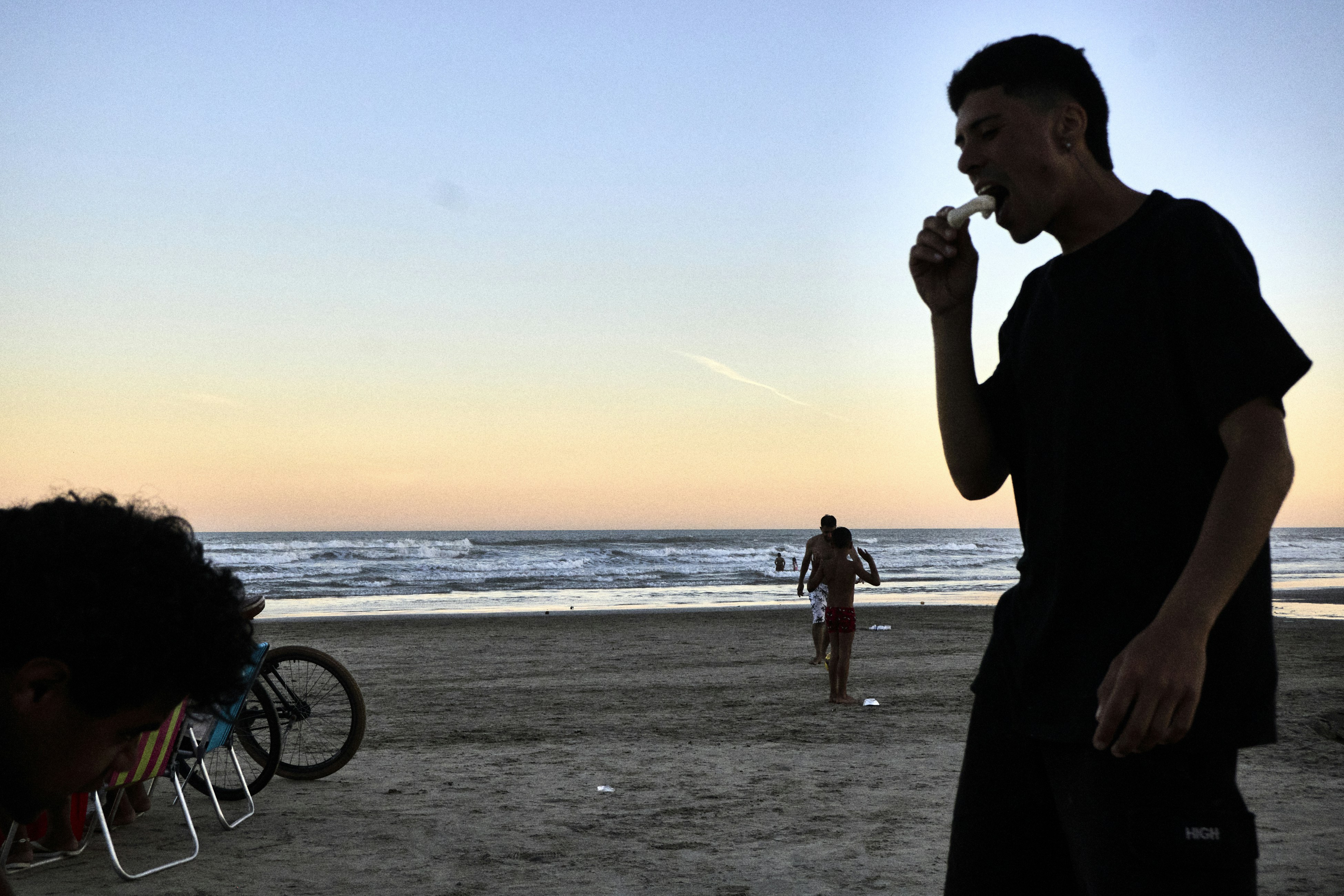 Sunset Silhouette and Quiet Snack Break on a Sandy Shore