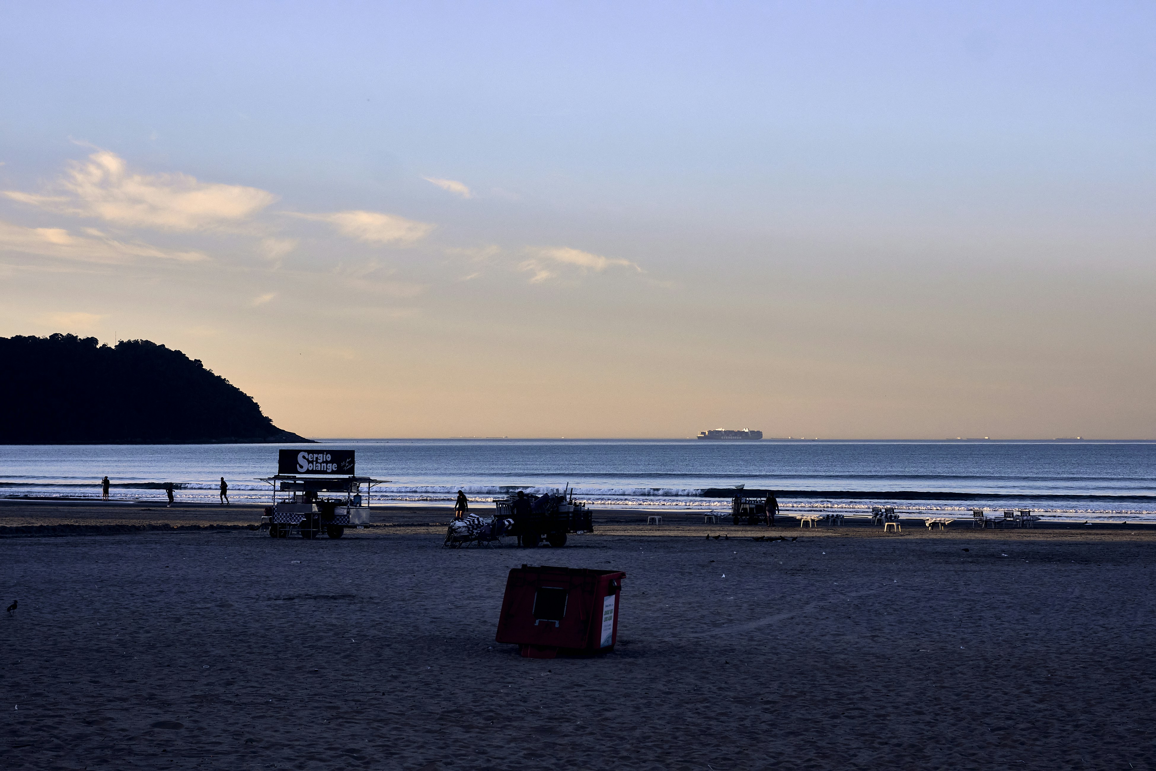 Quiet Beach at Dusk: Lifeguard Stand and Sailboat on the Horizon